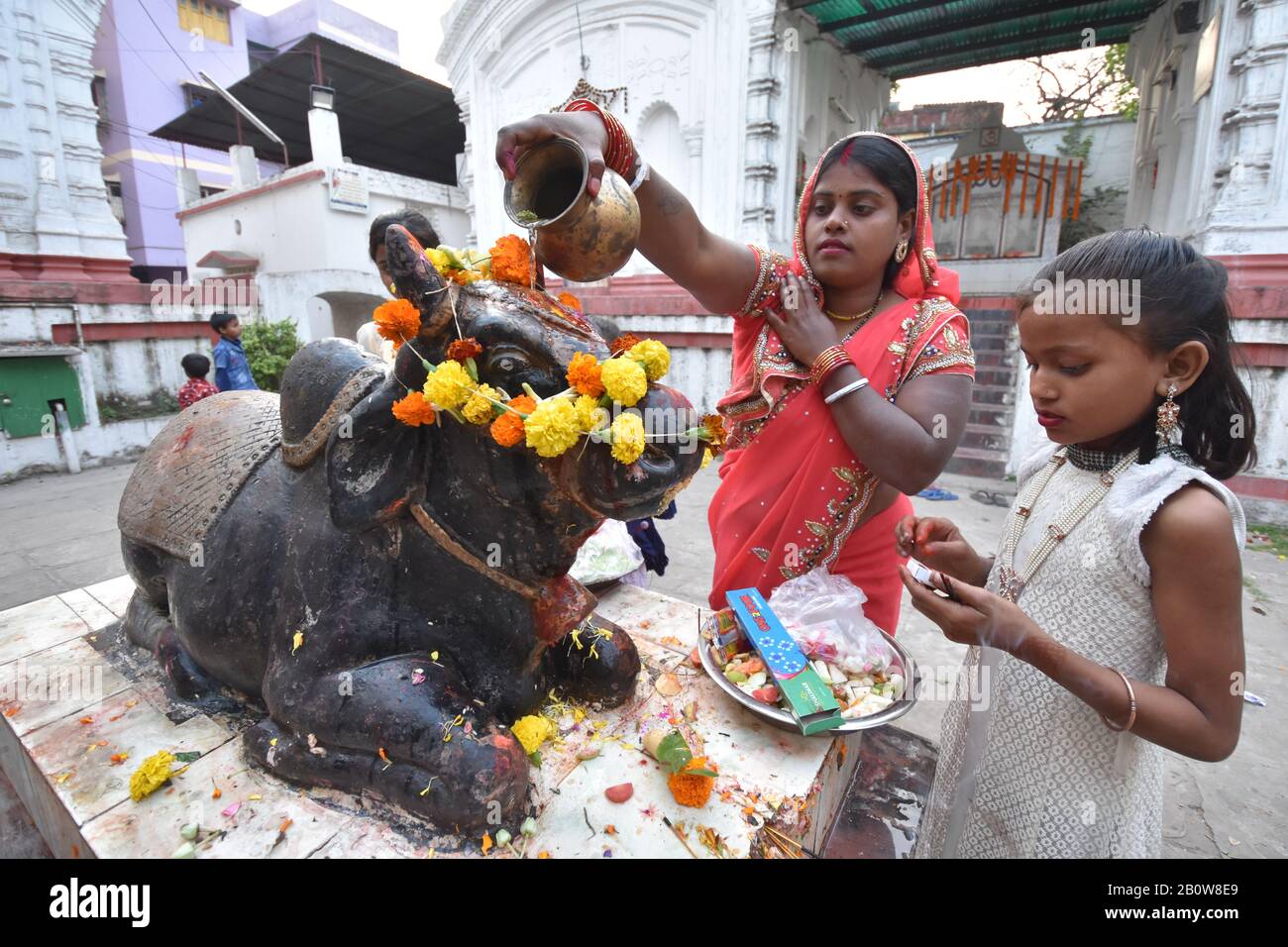 Howrah, India. 21st Feb, 2020. A Hindu woman devotee performs rituals to Nandi, bull vahana of ...