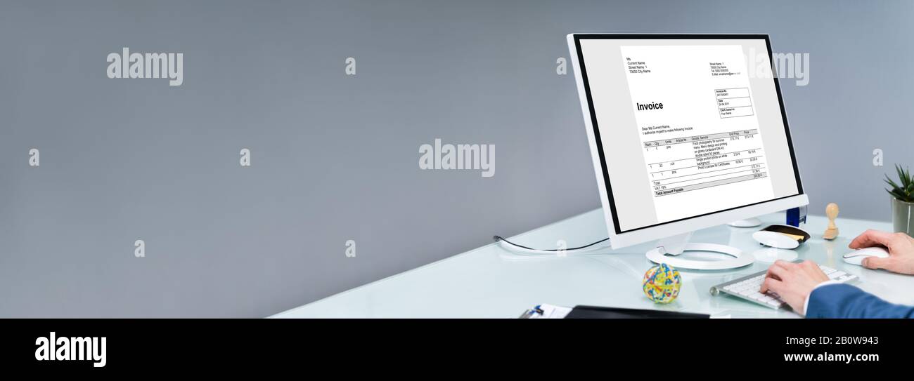 Accountant Making Invoice On Computer At Desk Stock Photo - Alamy