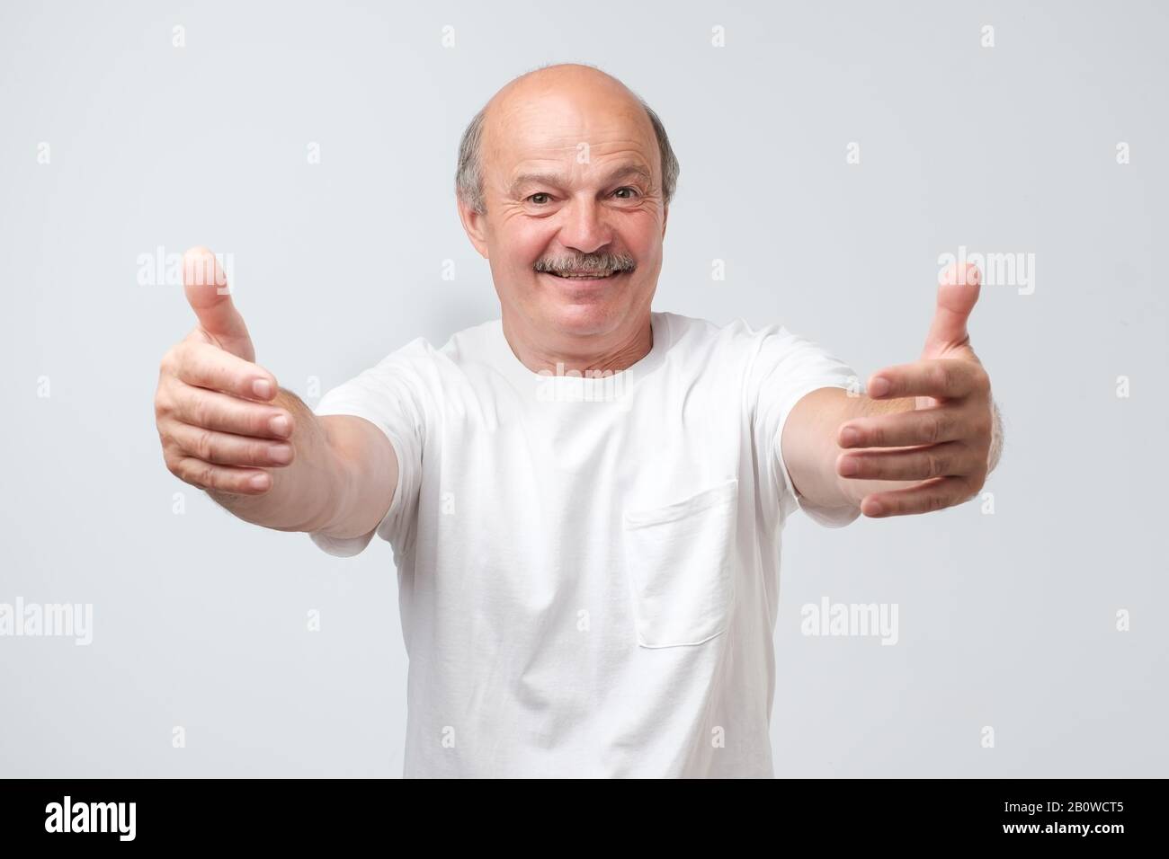 Free hugs for person who had bad day. Cheerfull senior man pulling ...