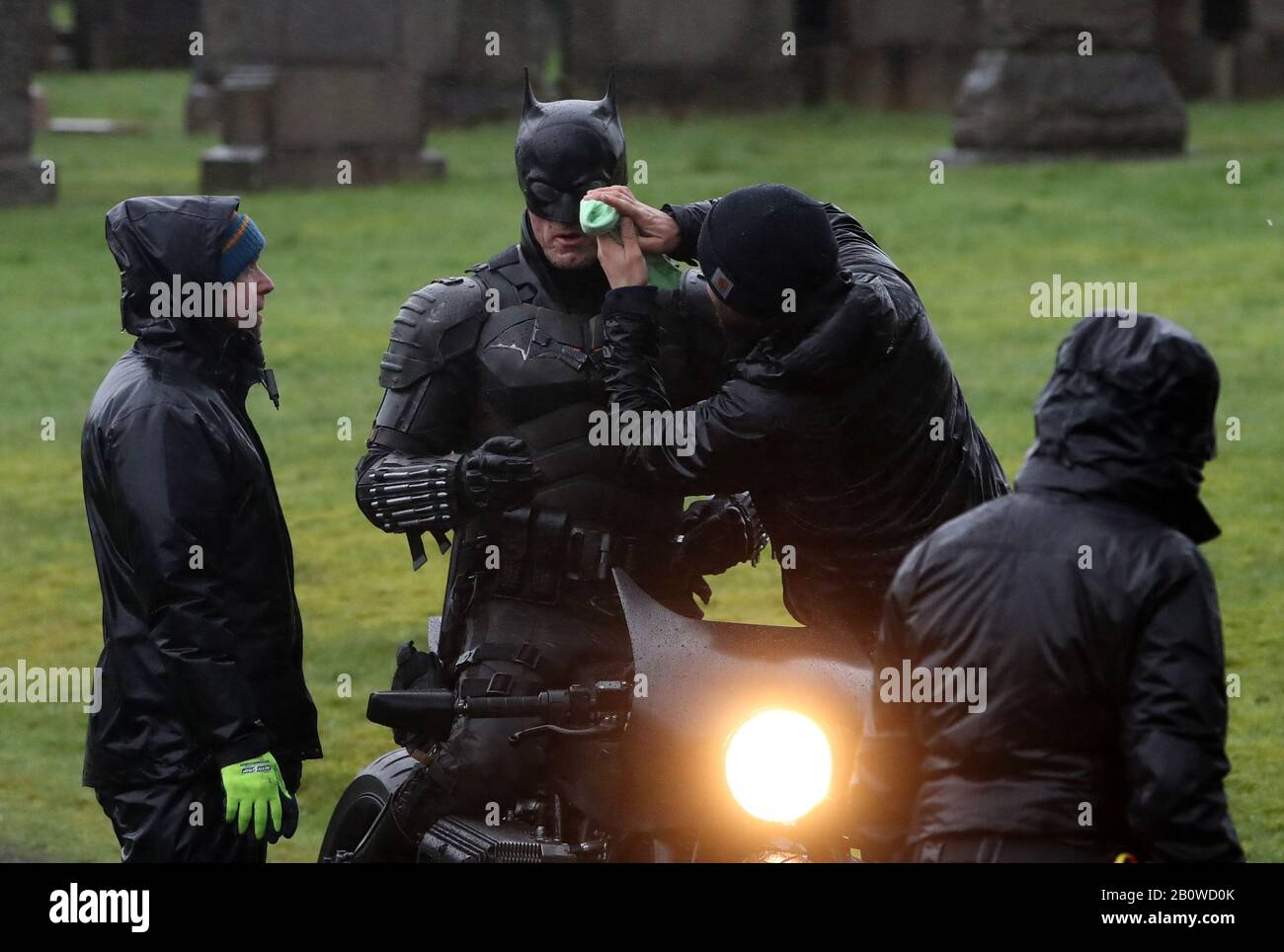 A man dressed as Batman has his face wiped during filming at the ...
