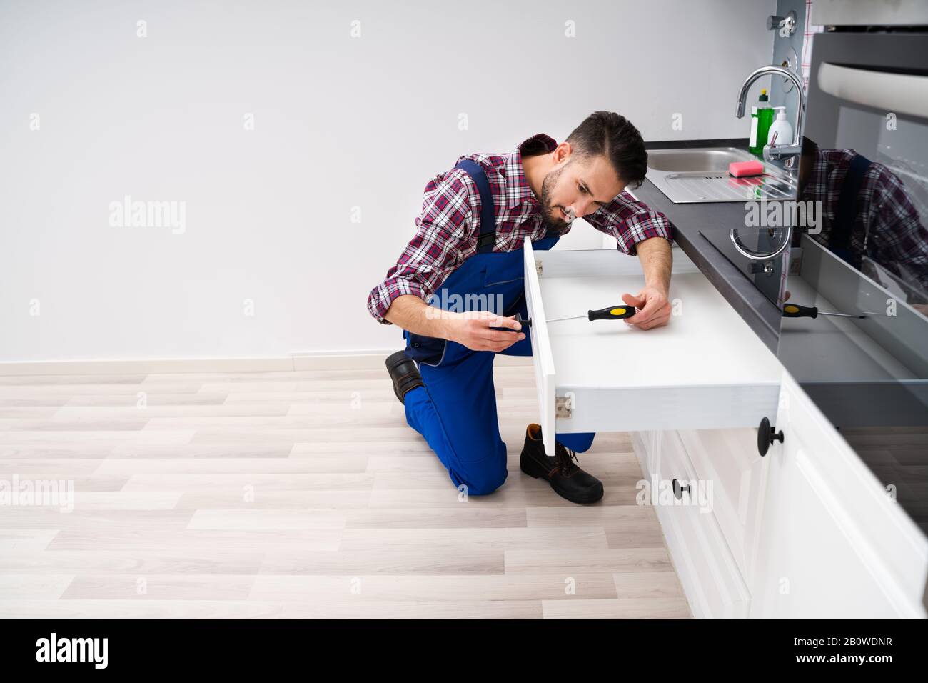 Close-up Of A Young Male Carpenter Installing Drawer With Screwdriver ...