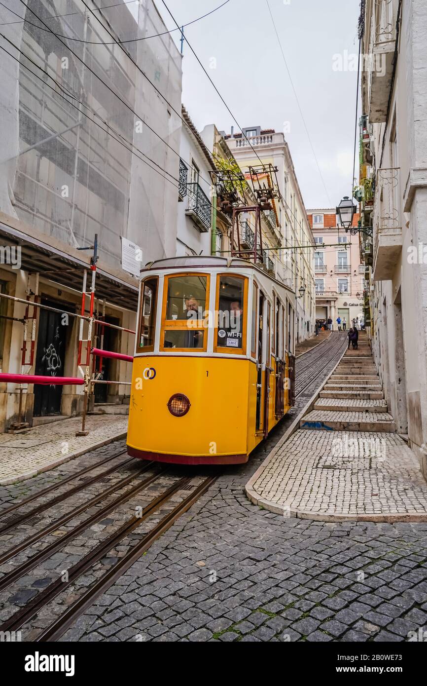 The famous Elevador da Bica funicular moving on steep hill in Lisbon ...