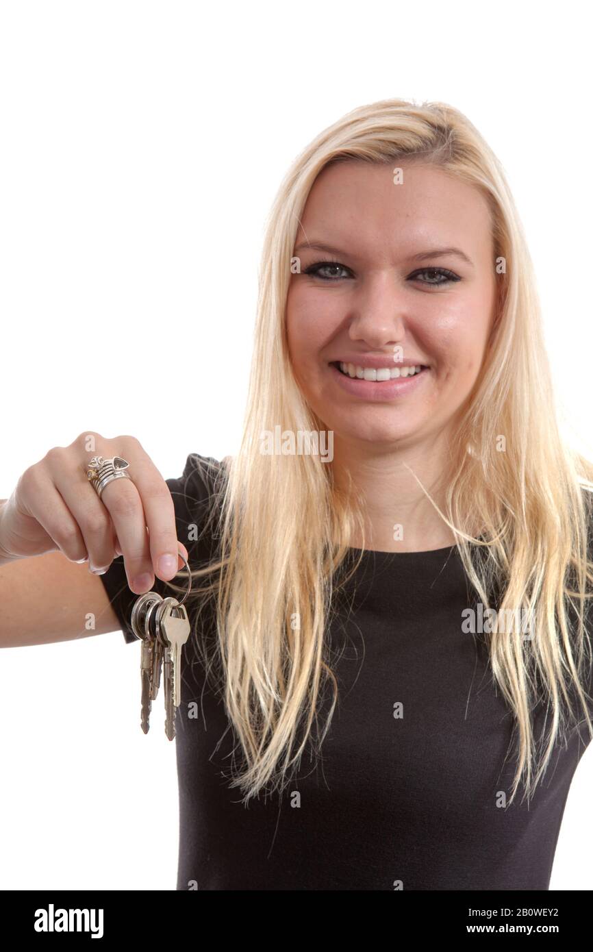 Young blonde woman is handing over keys over white background Stock ...