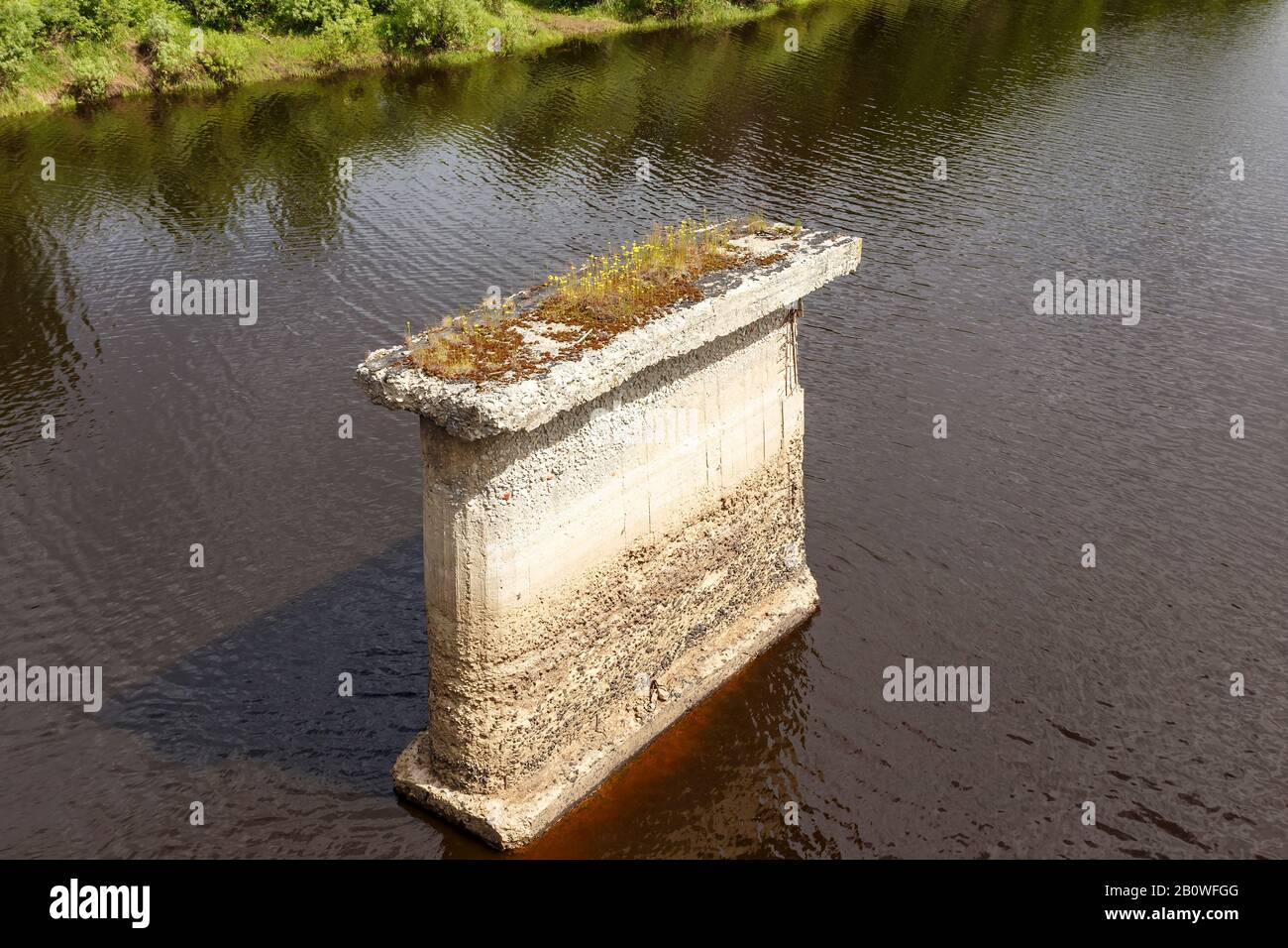 Old bridge support stands in river, support of the destroyed bridge ...