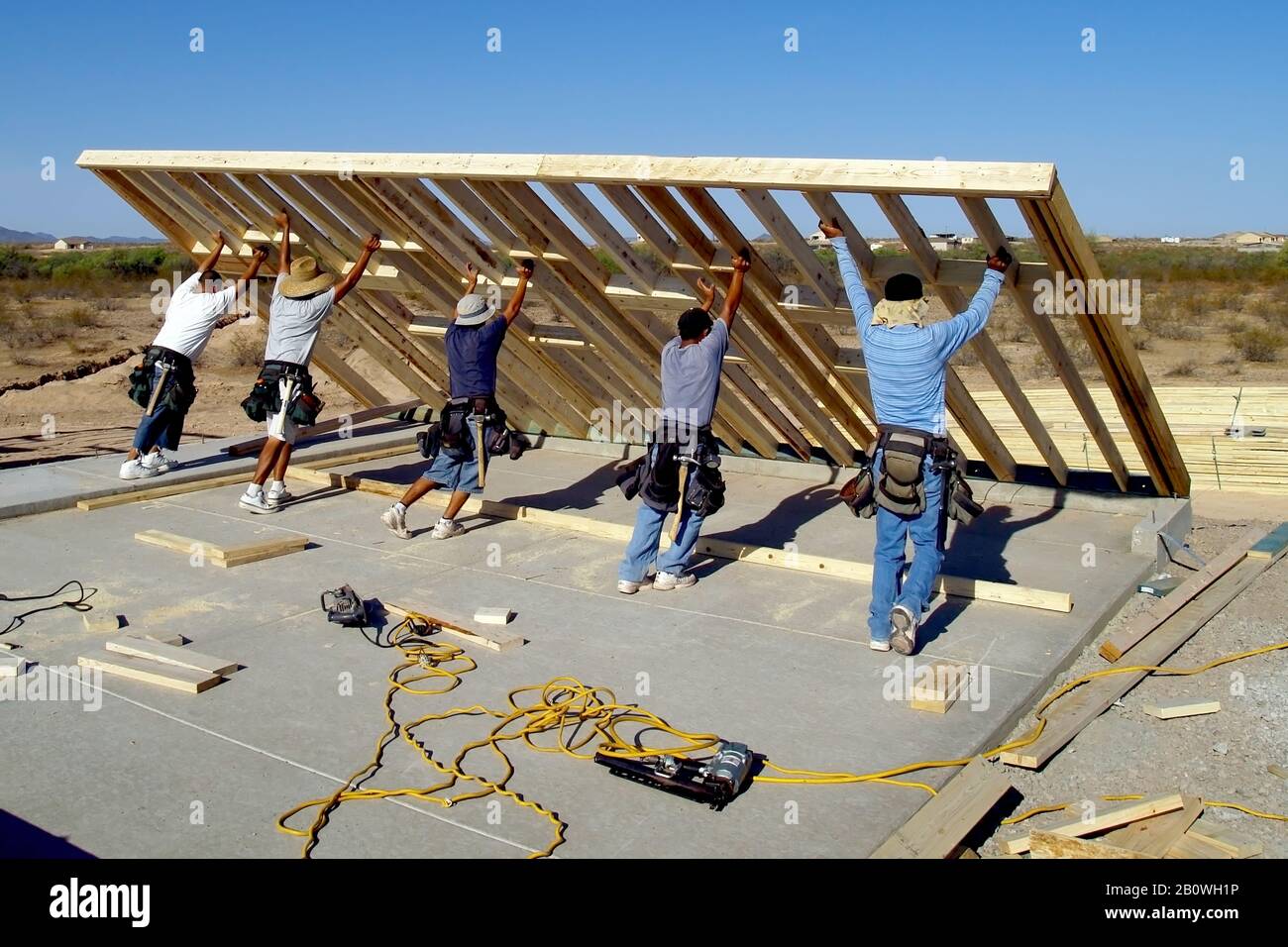 Taken in 2008. A group of construction workers raising a wood frame for ...