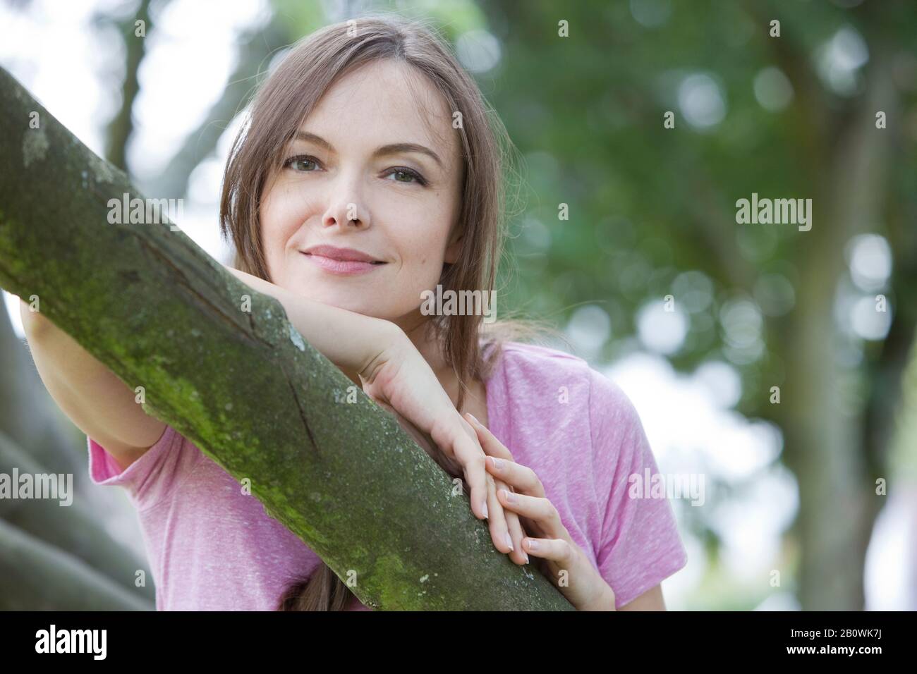 Woman standing tree branch hi-res stock photography and images - Alamy
