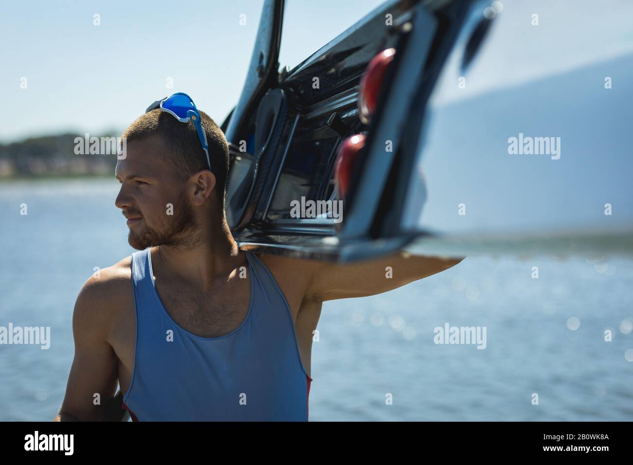 Caucasian man carrying a rowing boat Stock Photo - Alamy