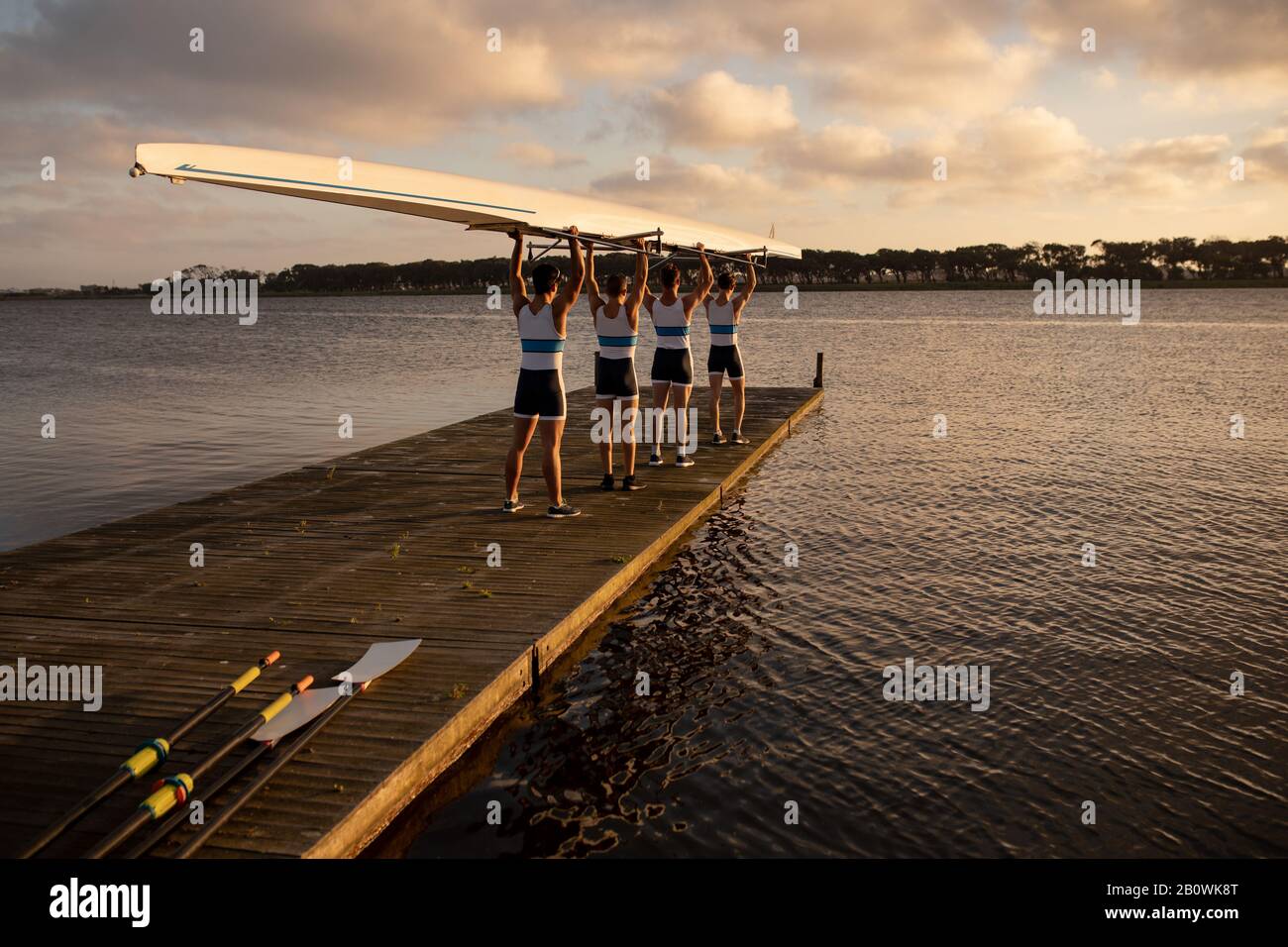 Teammates carrying the rowing boat together Stock Photo - Alamy