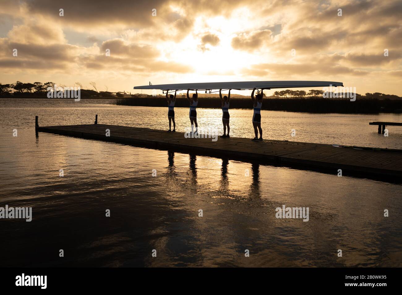 Teammates carrying the rowing boat together Stock Photo - Alamy