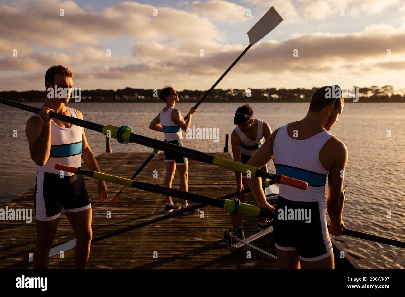 Teammates carrying the paddles before rowing Stock Photo - Alamy