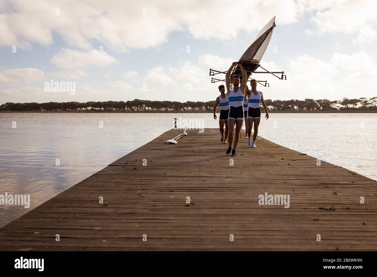 Teammates carrying the rowing boat together Stock Photo - Alamy