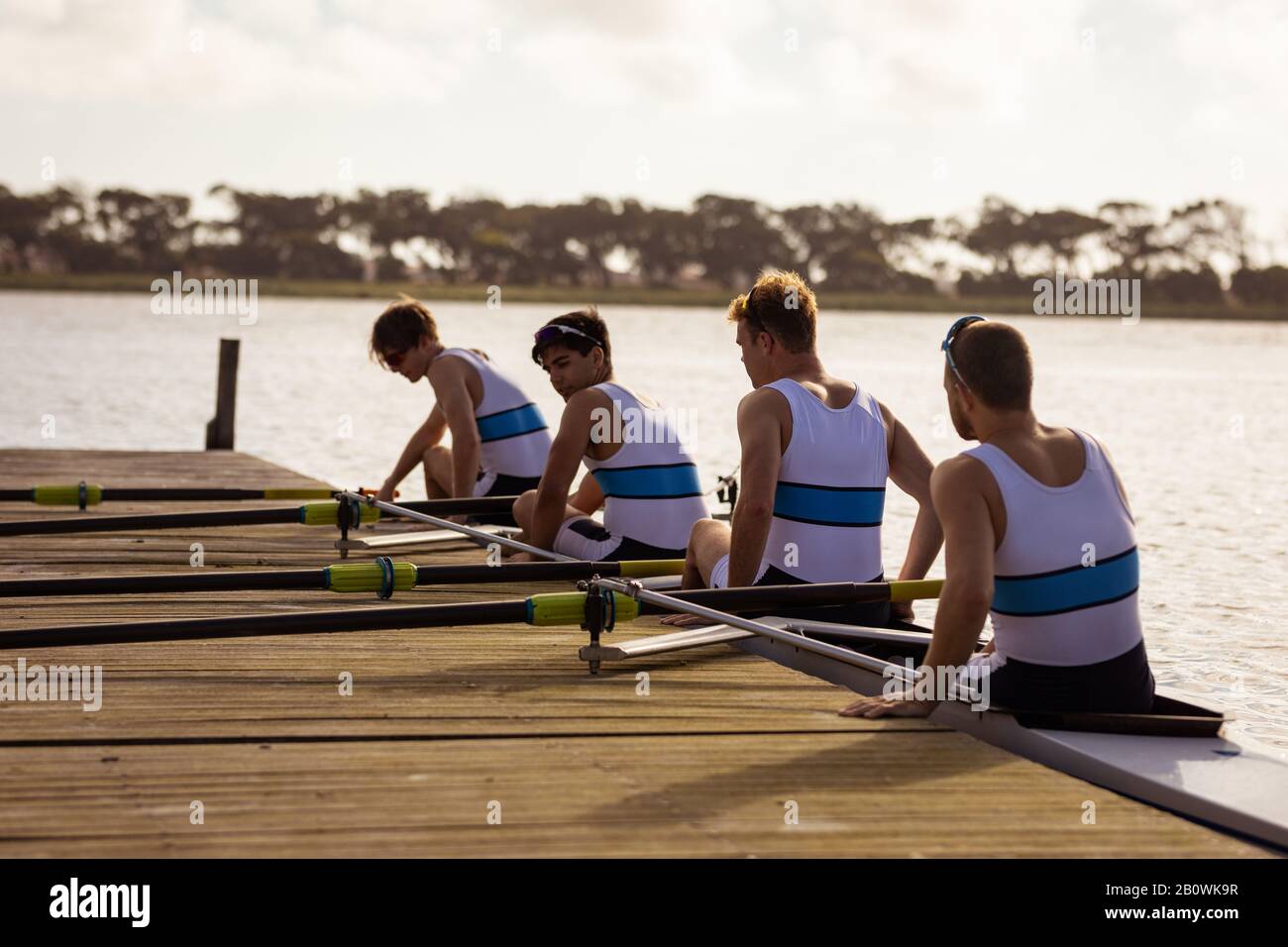 Teammates getting off the rowing boat Stock Photo - Alamy