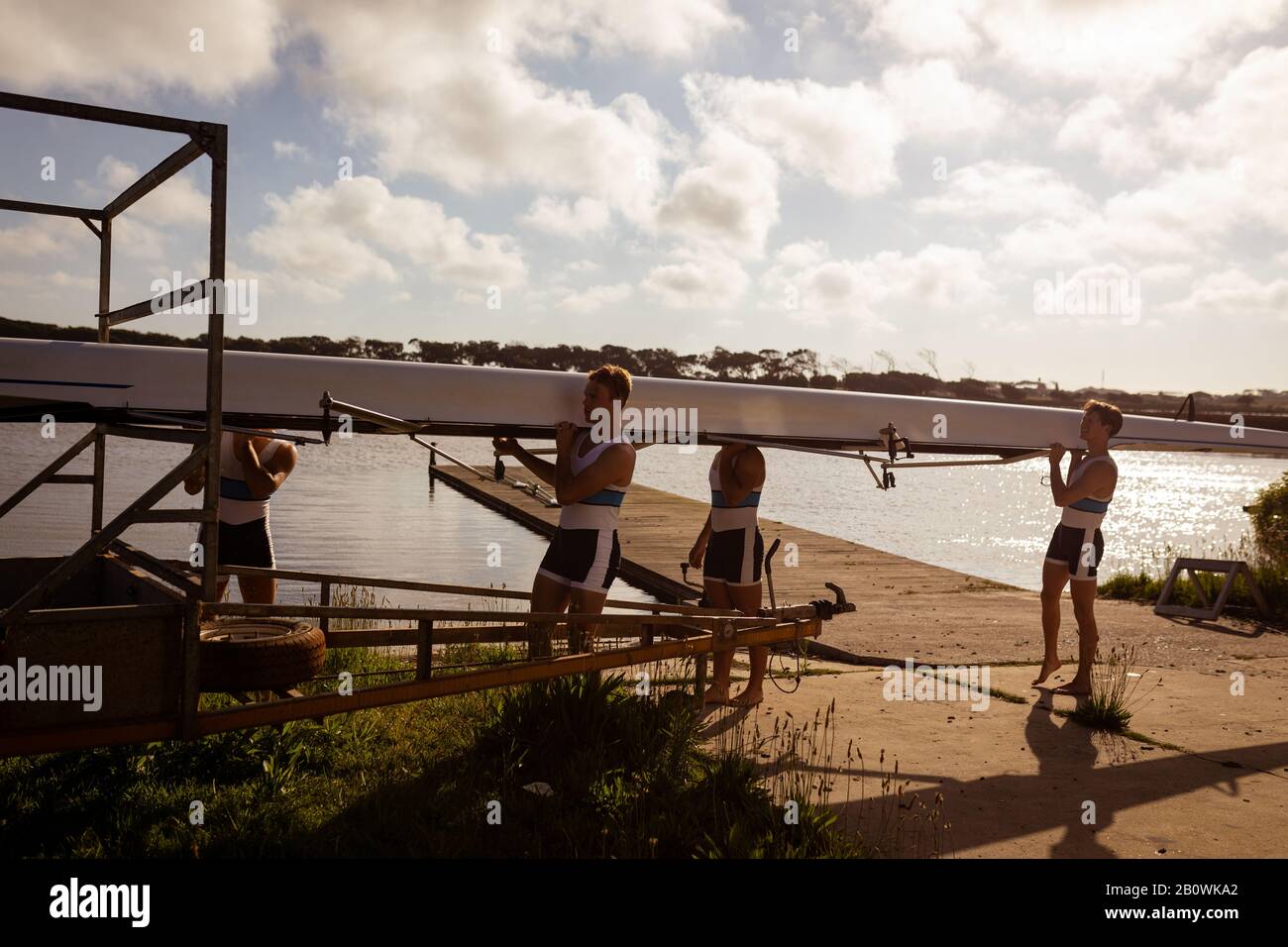 Teammates carrying the rowing boat together Stock Photo - Alamy