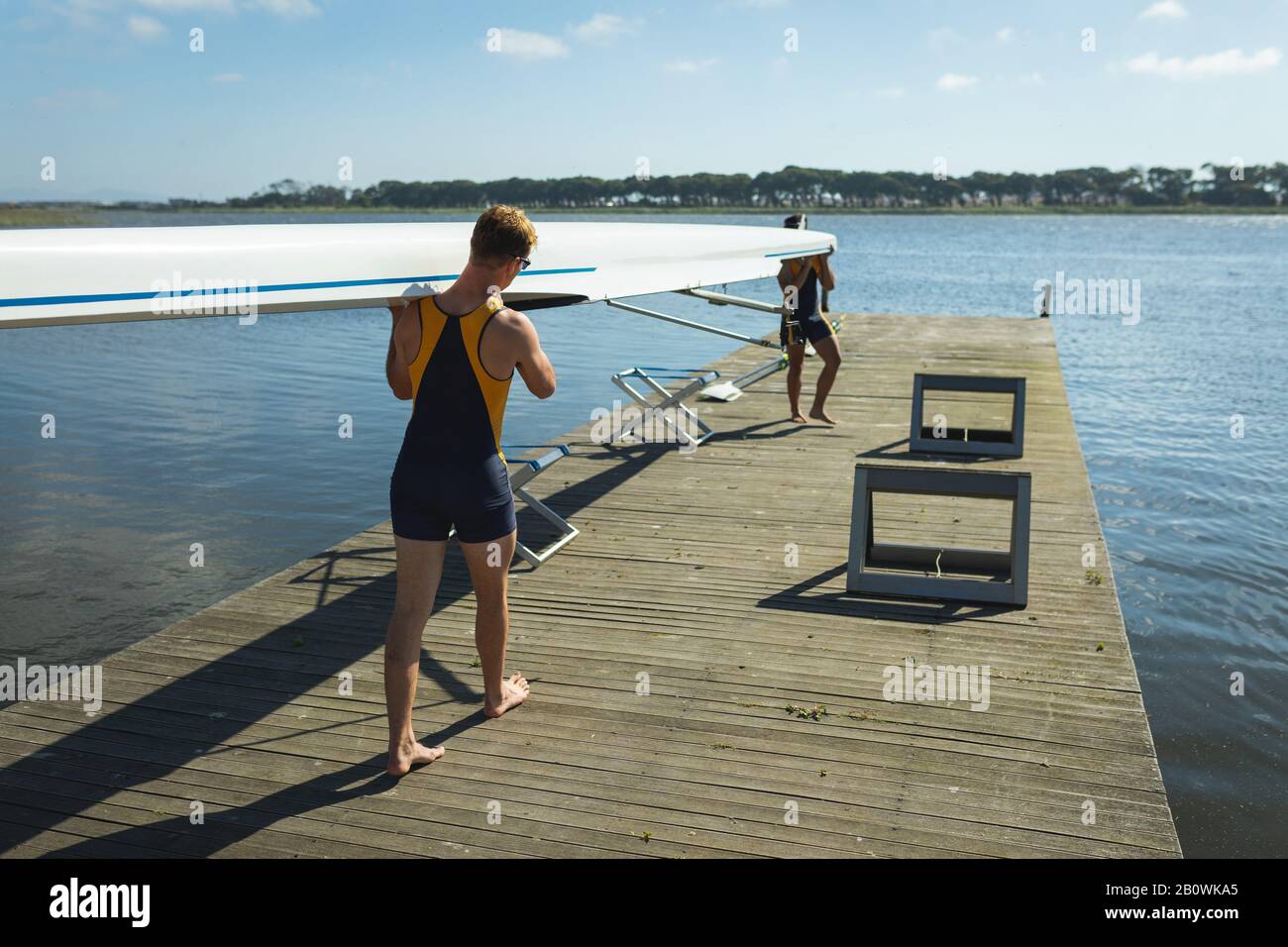 Teammates carrying the rowing boat together Stock Photo - Alamy