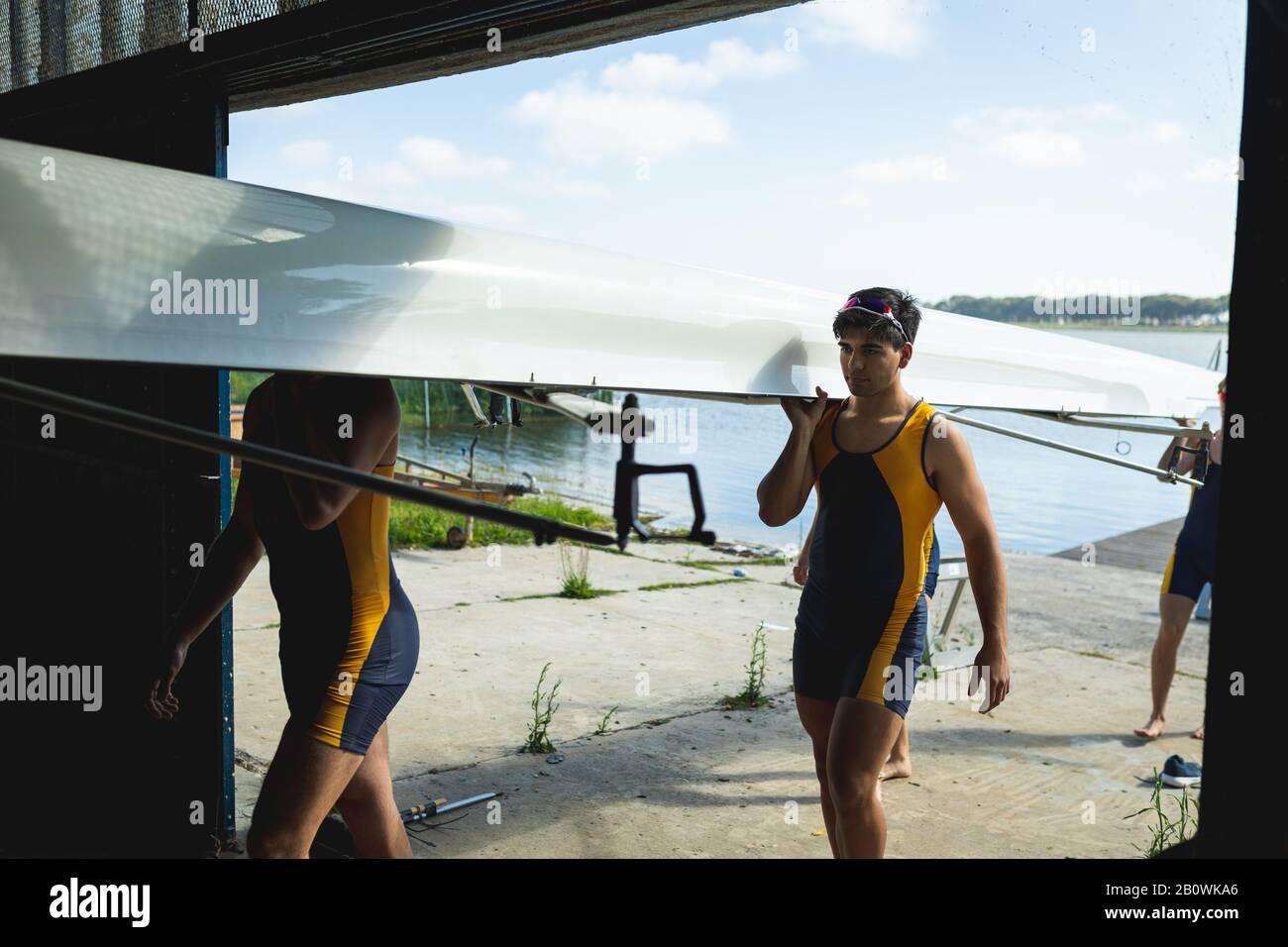 Teammates carrying the rowing boat together Stock Photo - Alamy