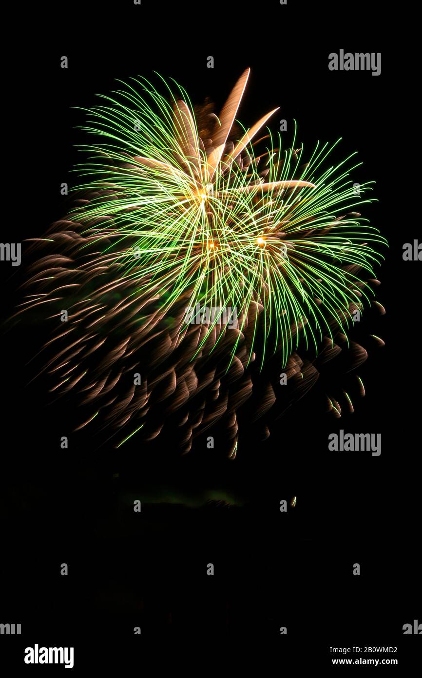 Green and gold fireworks display in front of a black sky at an event in ...