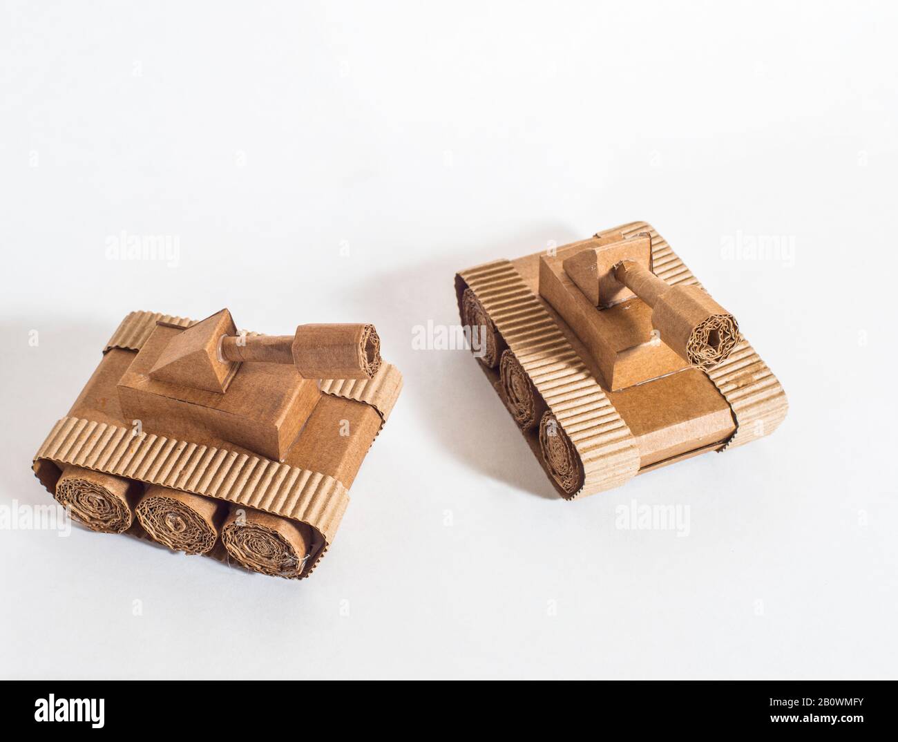 two toy tanks made by children from corrugated cardboard are fighting ...