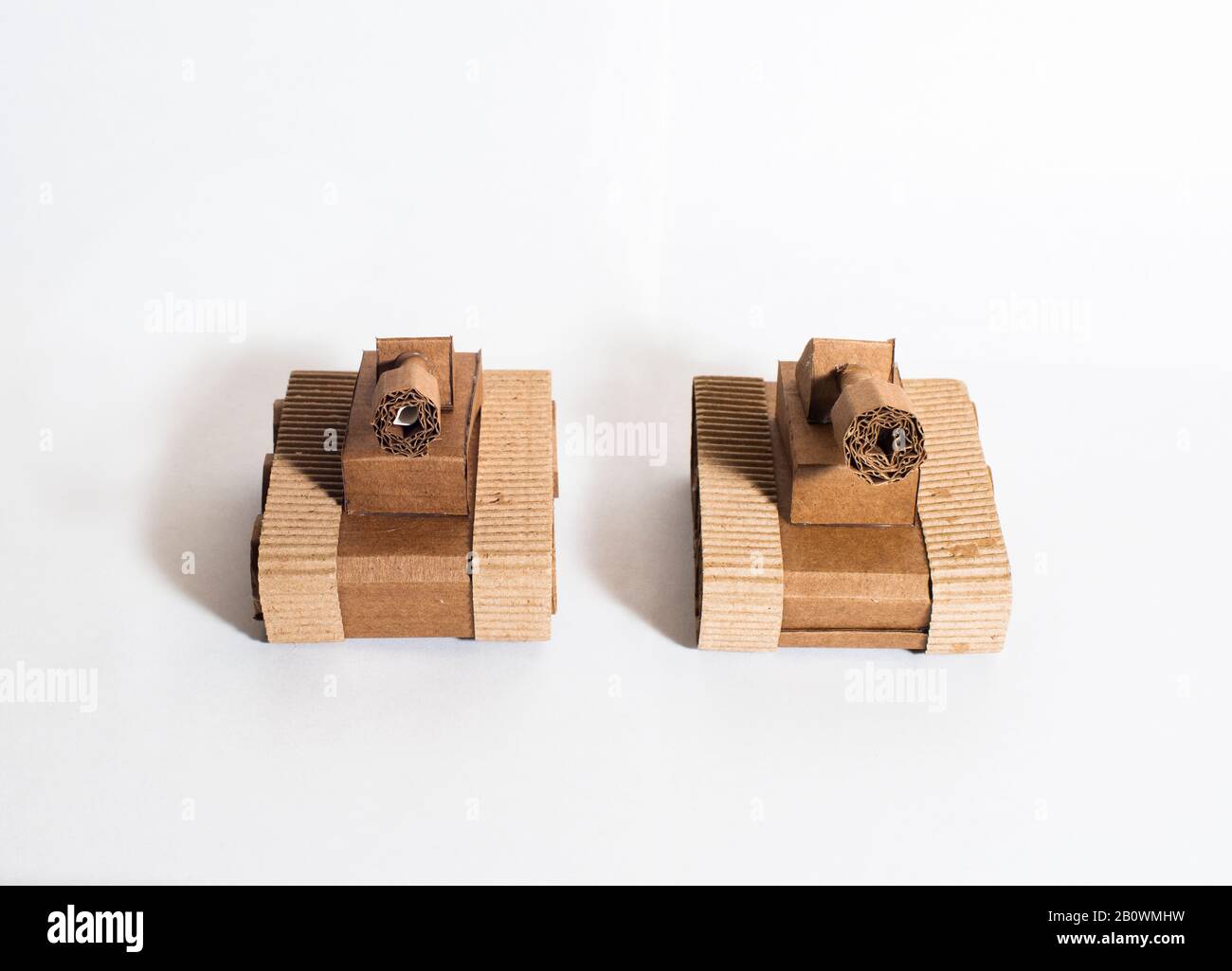 two toy tanks made by children from corrugated cardboard are fighting ...