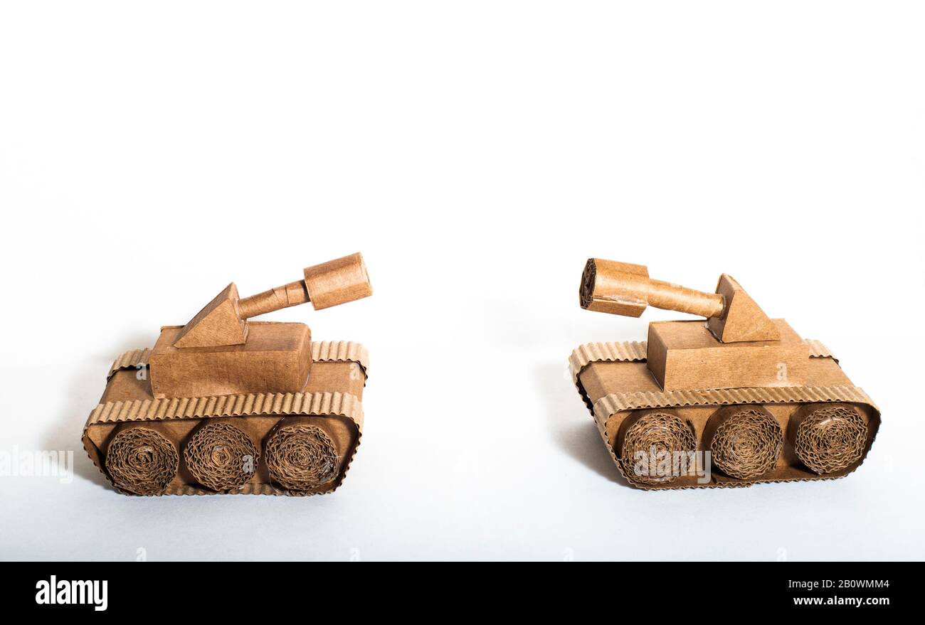 two toy tanks made by children from corrugated cardboard are fighting ...