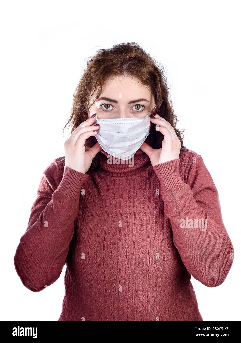 Girl with a medical mask on her face. Girl in a sweater isolated on a ...