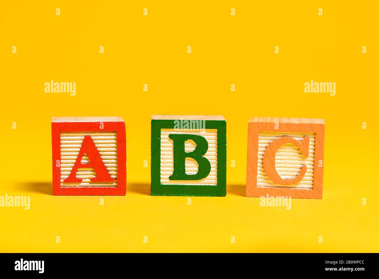 Wooden ABC blocks on yellow background Stock Photo - Alamy