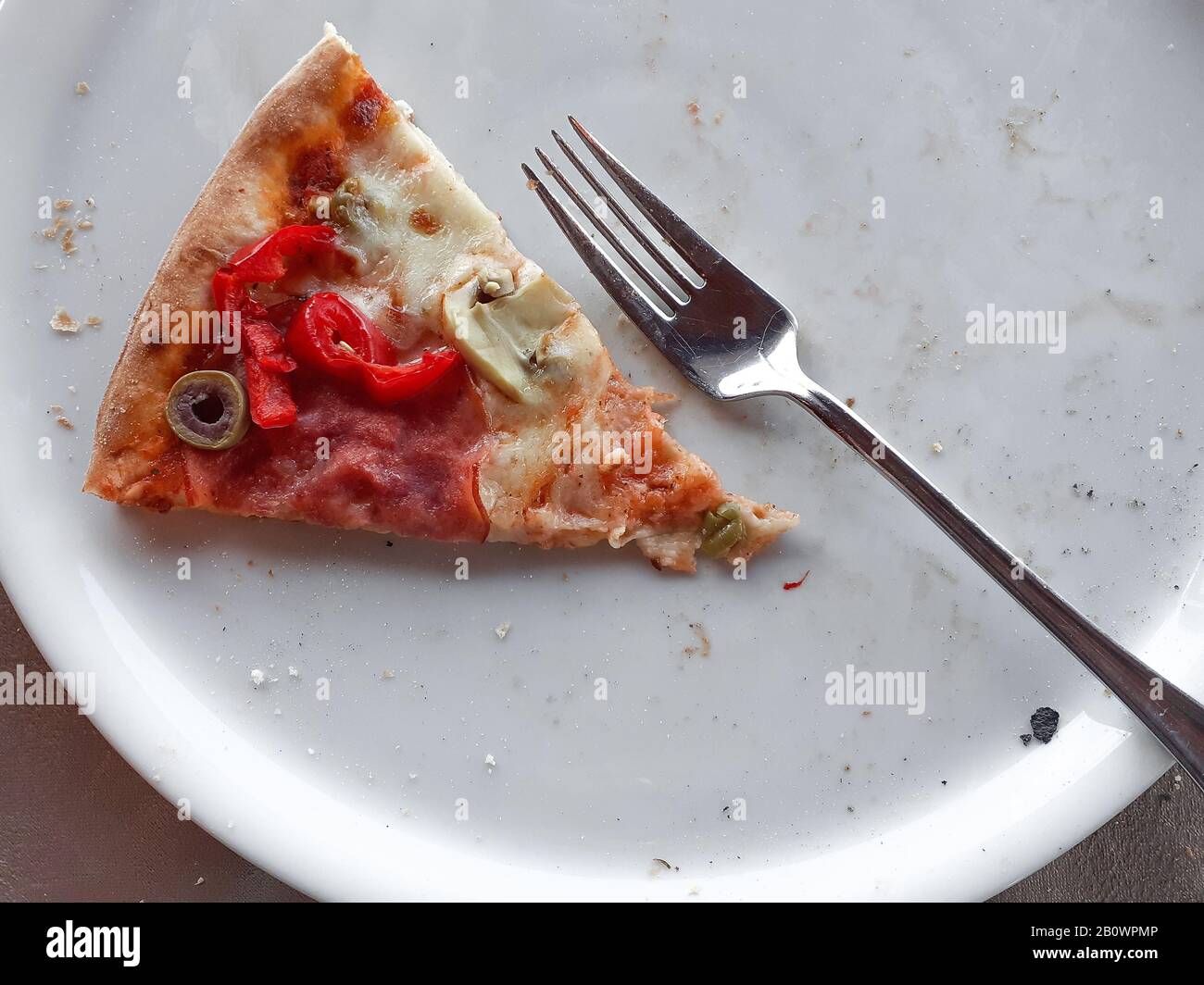 The last piece of pizza in the plate, junk food Stock Photo - Alamy