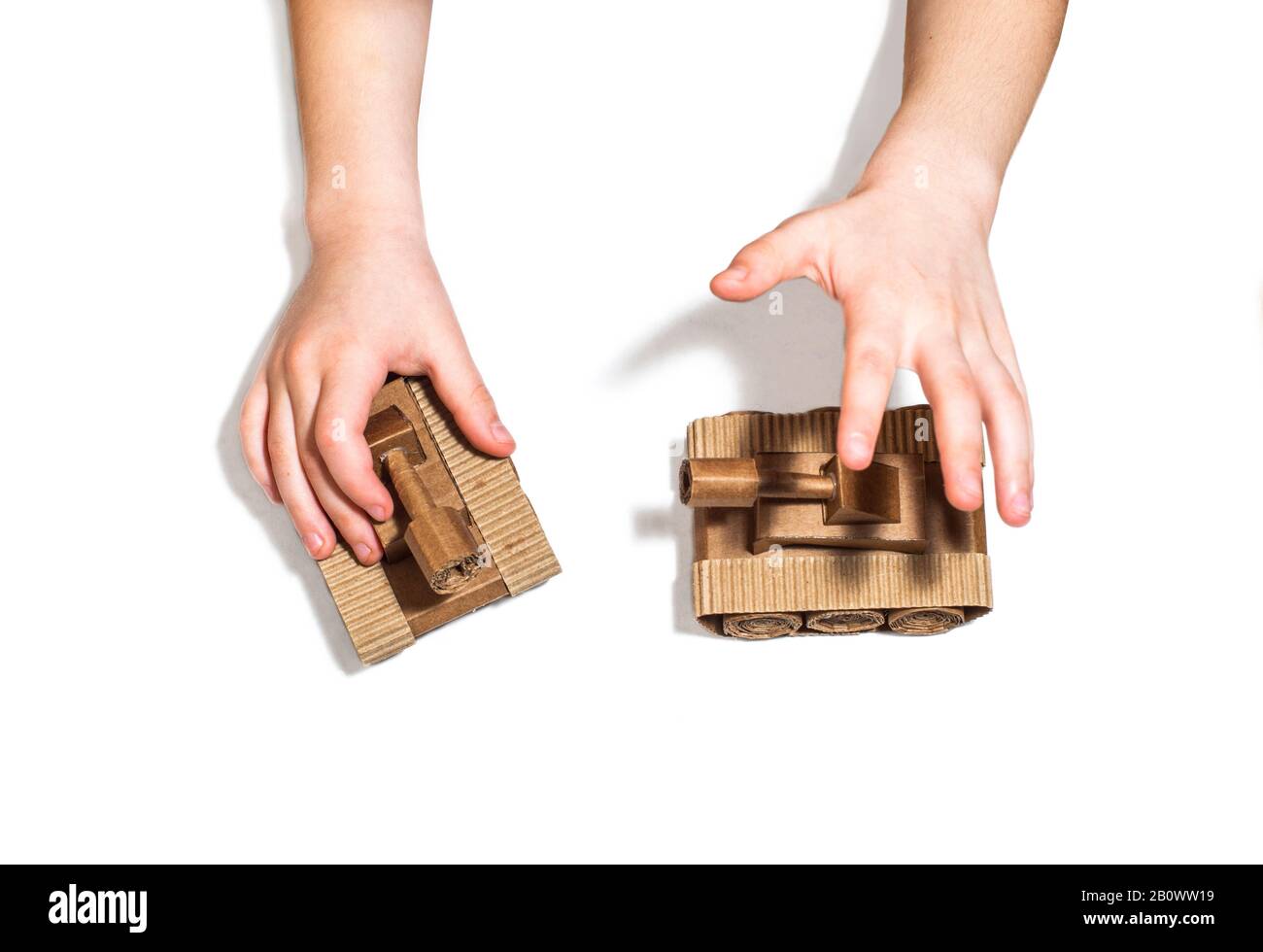 children's hands play with tanks. two toy tanks made by children from ...