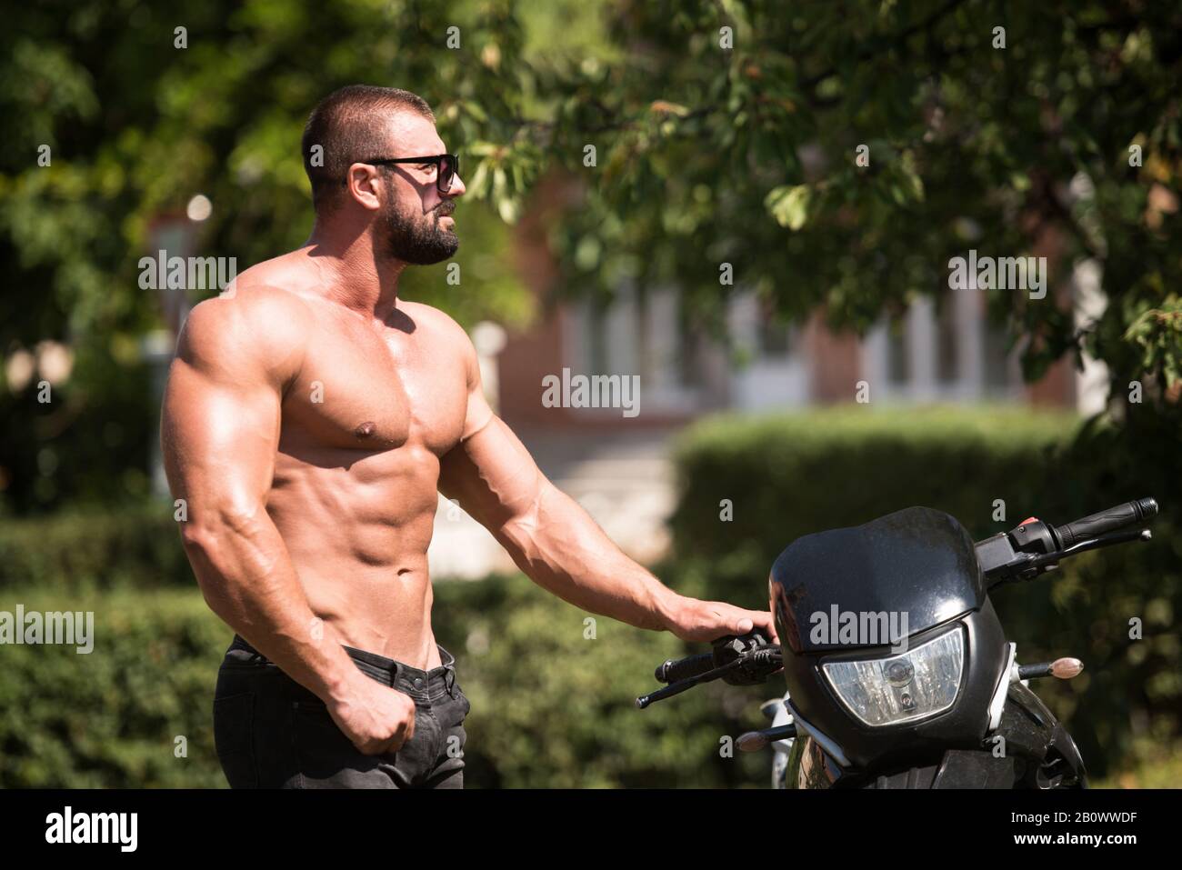 Biker Man Bodybuilder And The Bike Stock Photo - Alamy