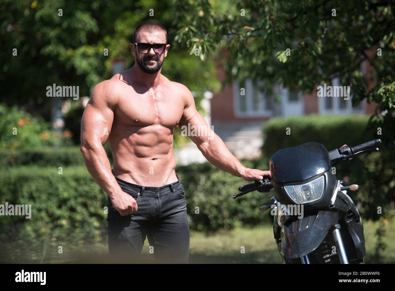 Biker Man Bodybuilder And The Bike Stock Photo - Alamy