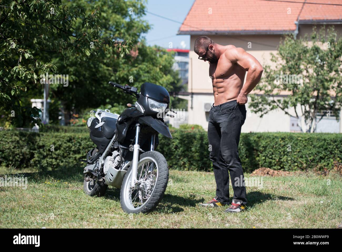 Biker Man Bodybuilder And The Bike Stock Photo - Alamy