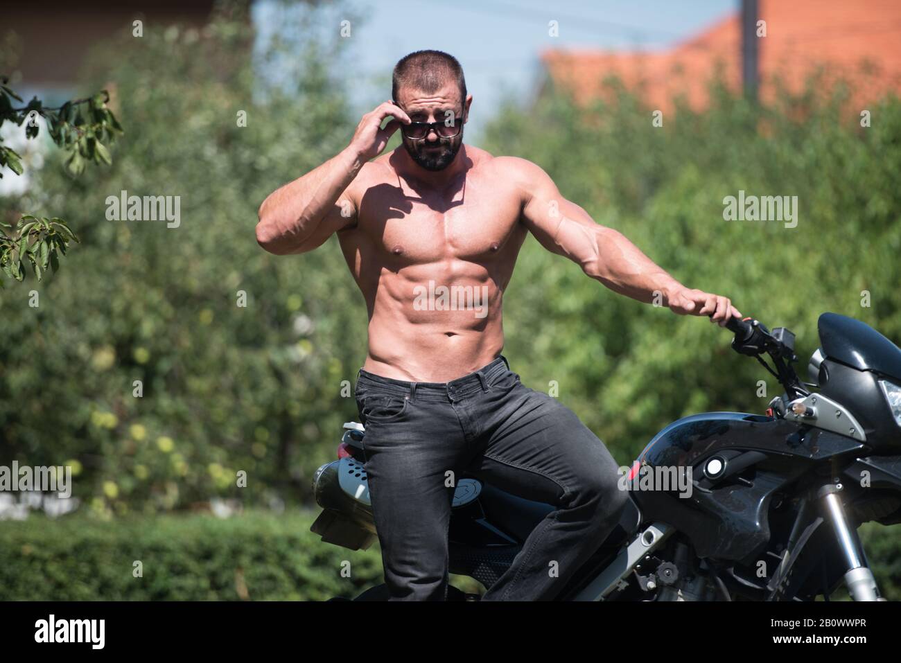 Biker Man Bodybuilder And The Bike Stock Photo - Alamy