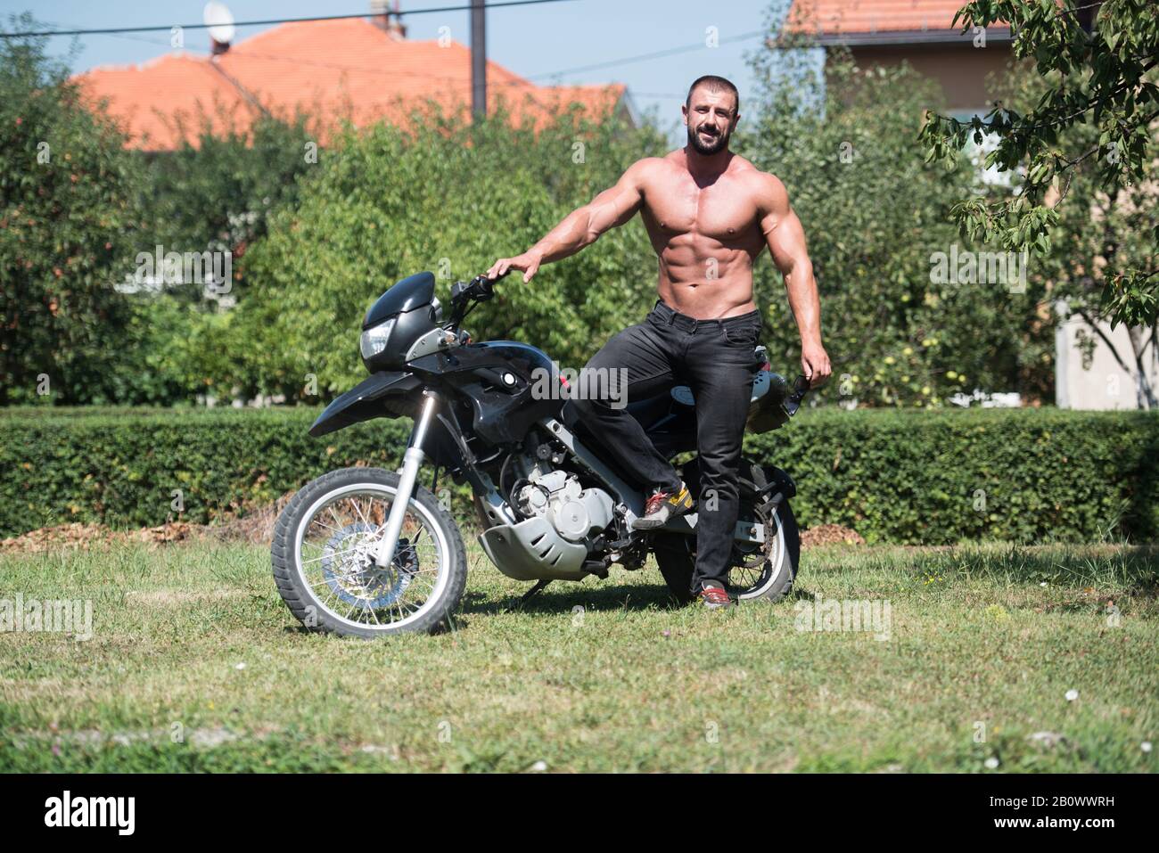 Biker Man Bodybuilder And The Bike Stock Photo - Alamy