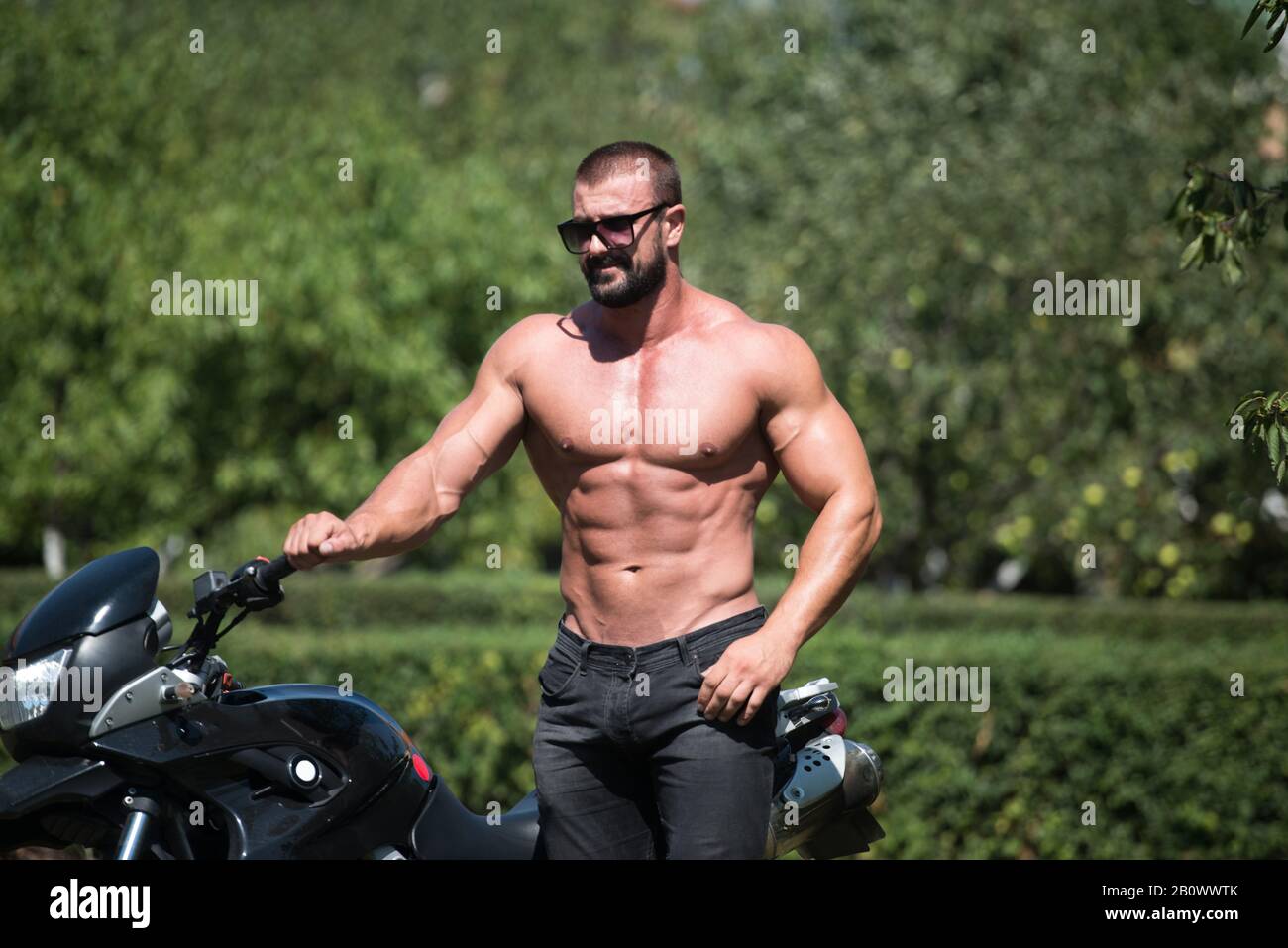 Biker Man Bodybuilder And The Bike Stock Photo - Alamy