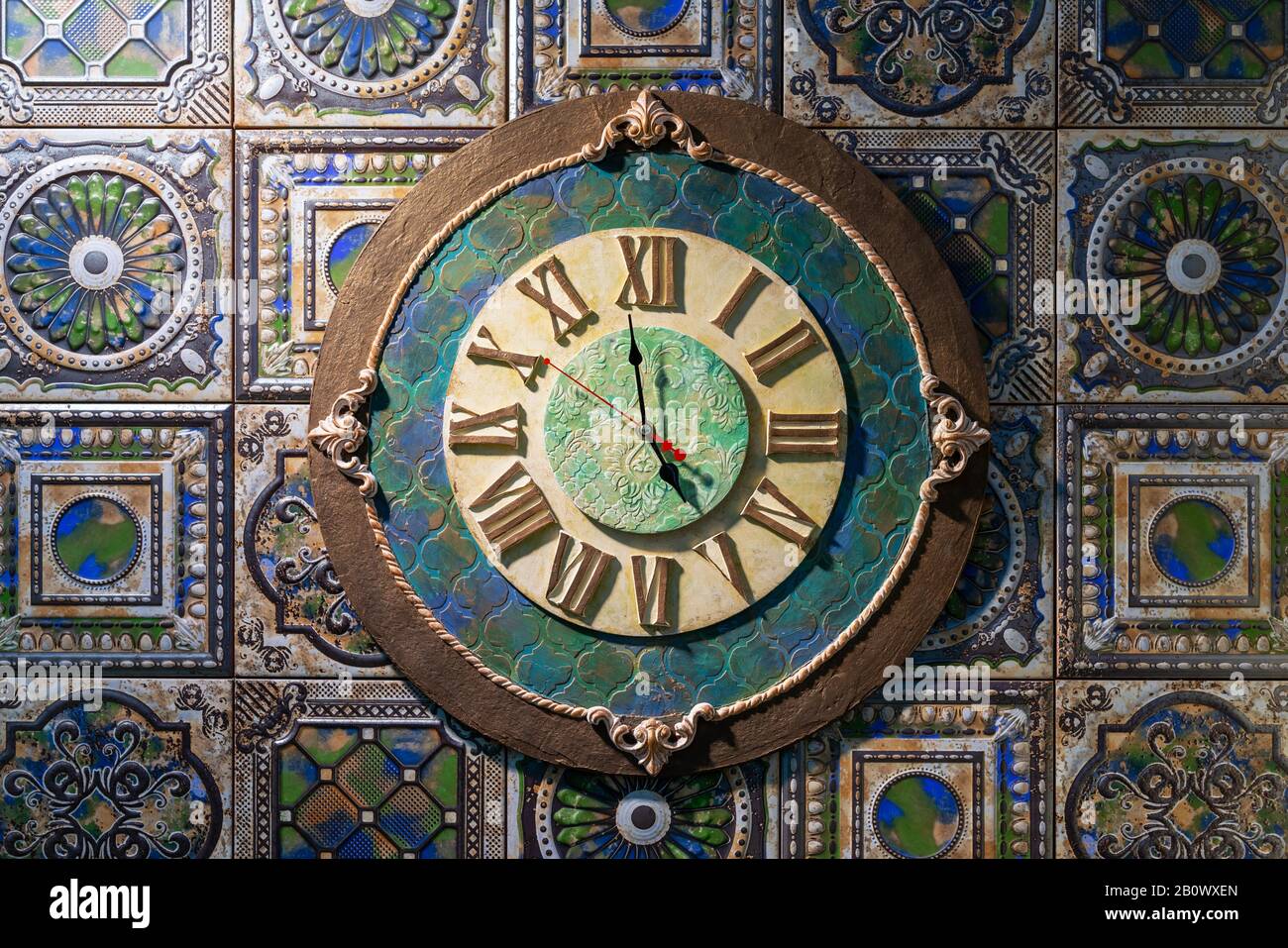 Ceramic wall clock with Roman dial against the background of ancient ...