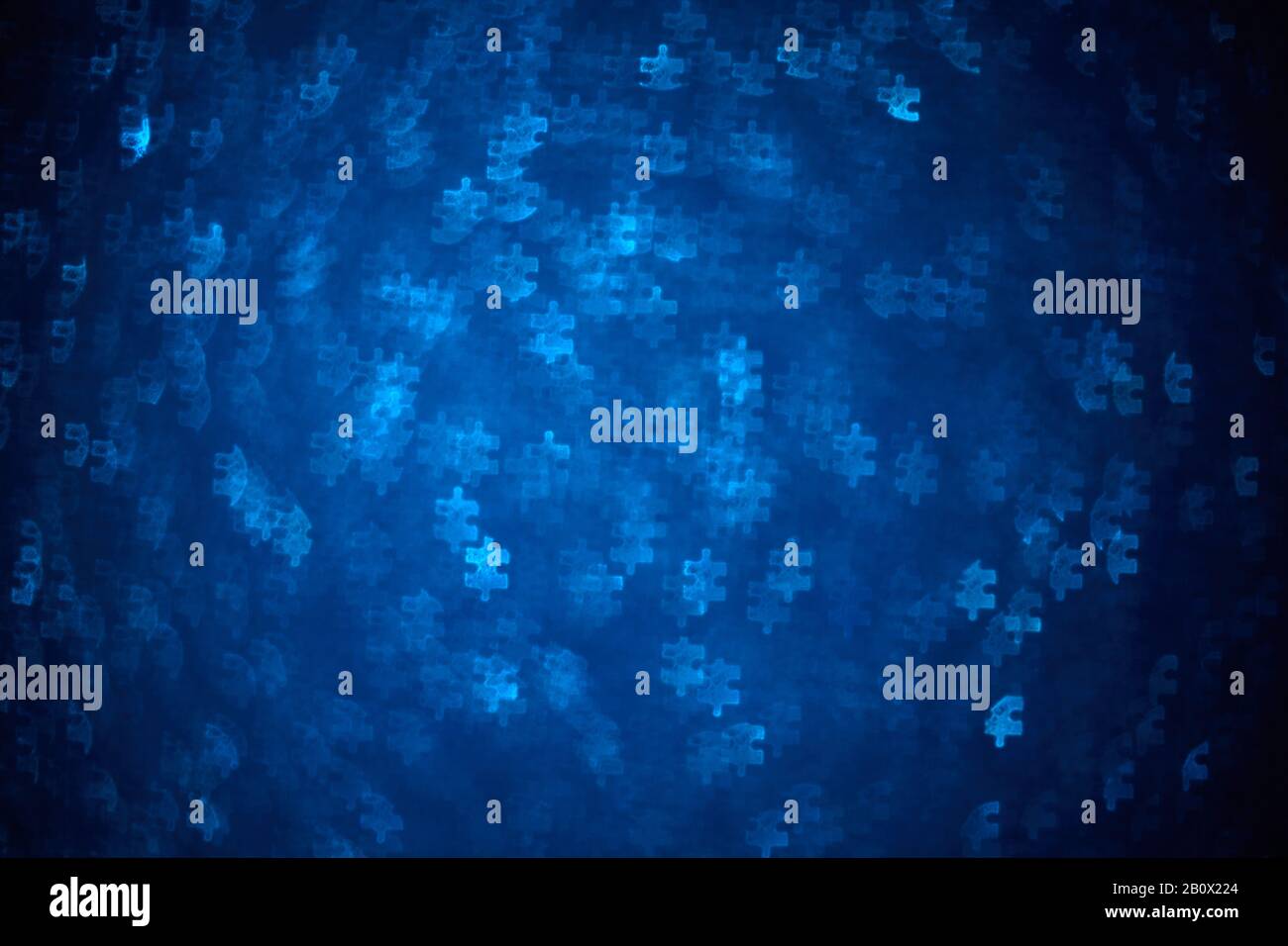 Blue Puzzle shape bokeh. Defocused background for autism awareness day ...