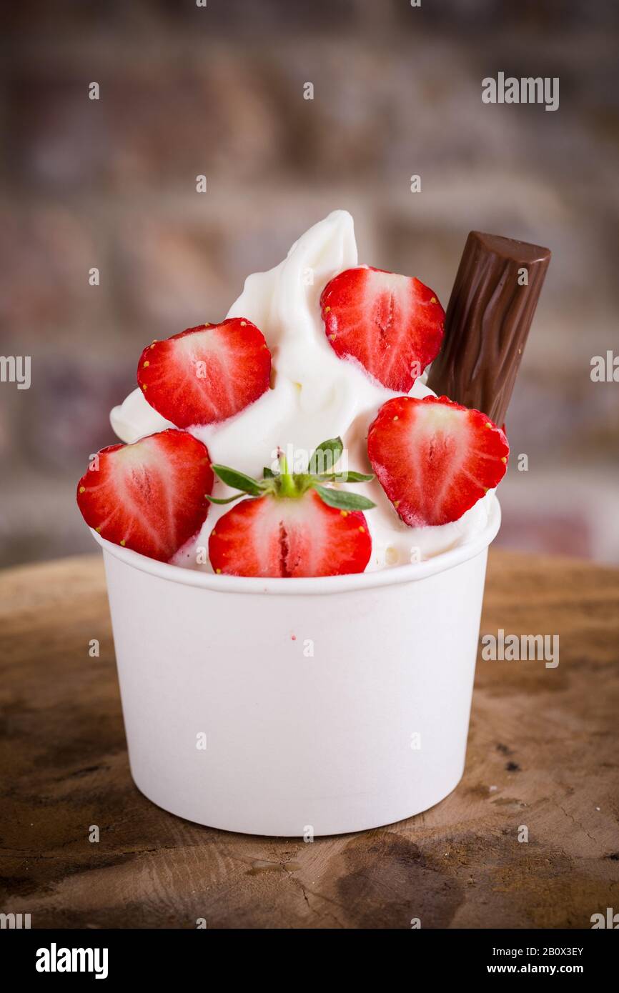 Frozen Yoghurt in a paper cup with toppings Stock Photo - Alamy