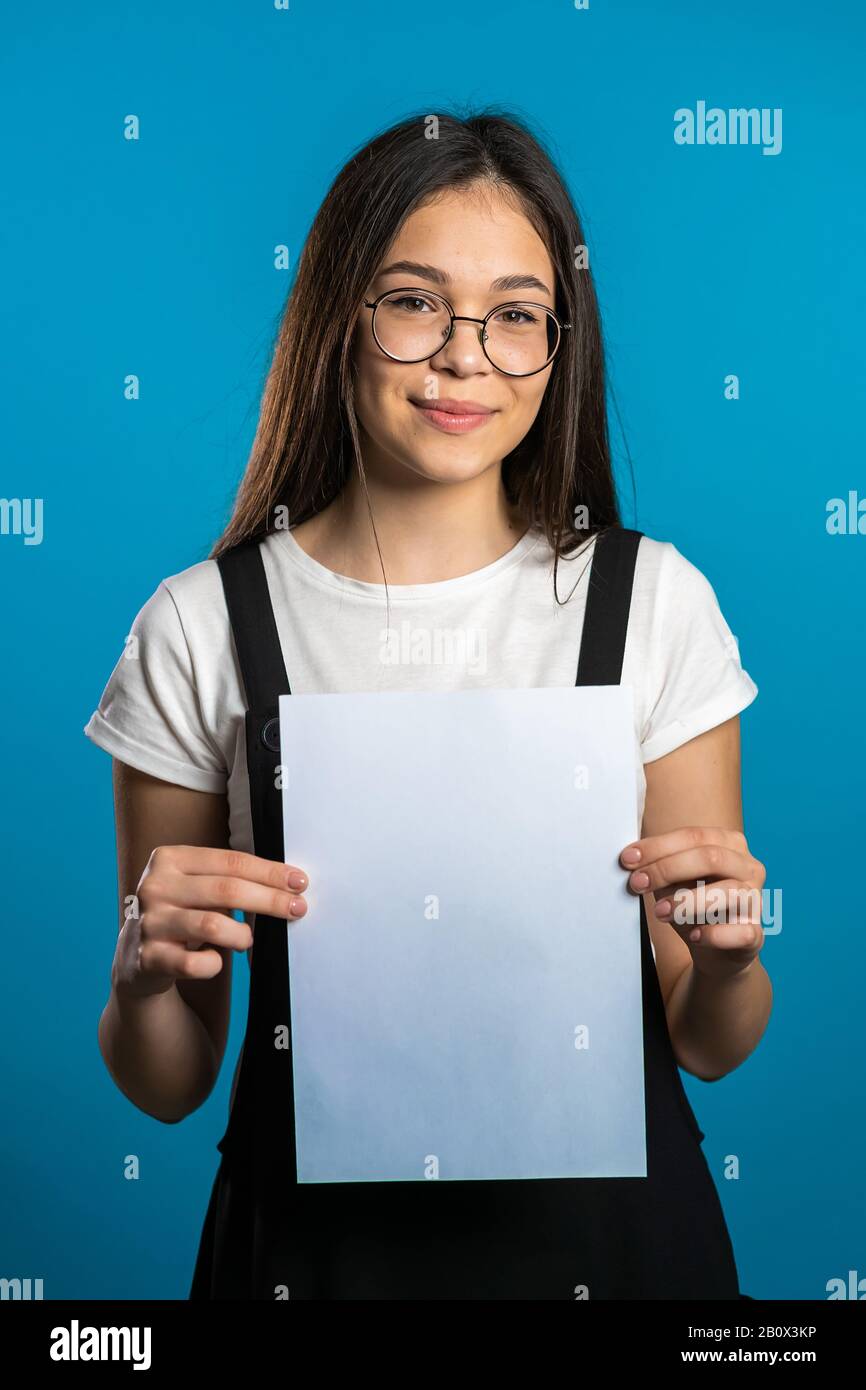 Pretty asian girl holding white a4 paper poster. Copy space. Smiling ...