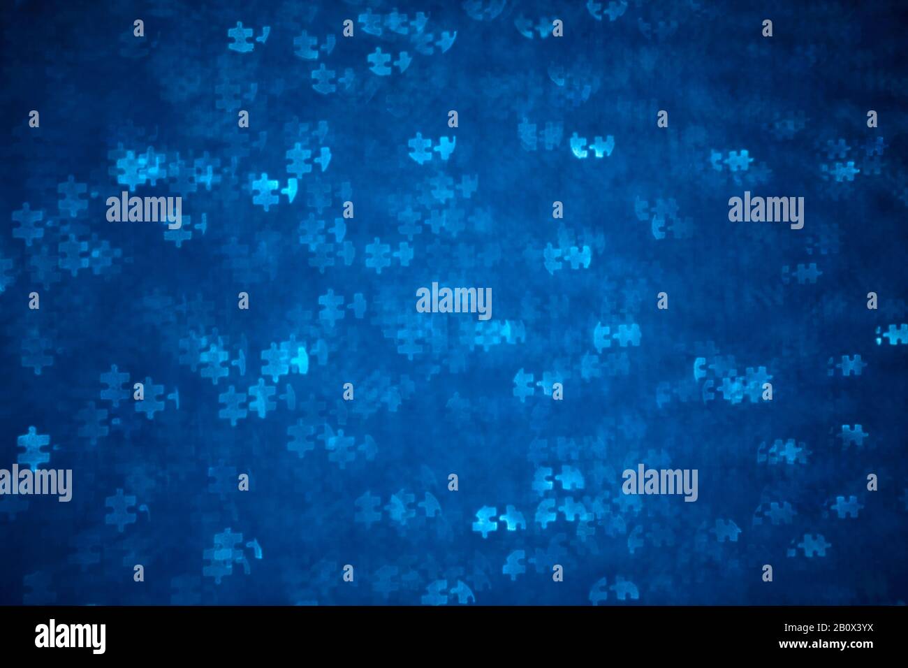 Blue Puzzle shape bokeh. Defocused background for autism awareness day ...