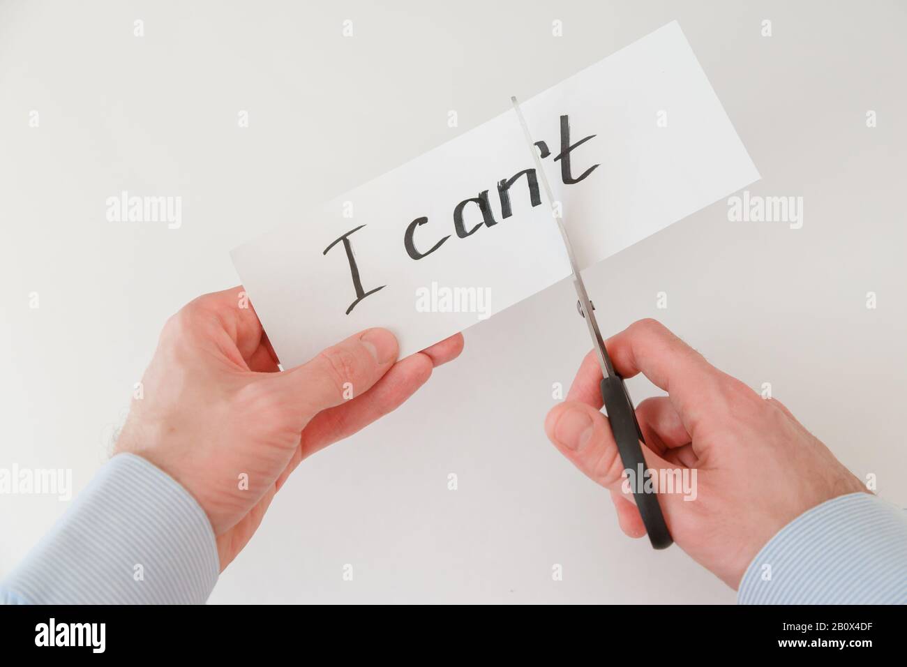 Businessman hands cutting the word can not, letter t so it become can ...