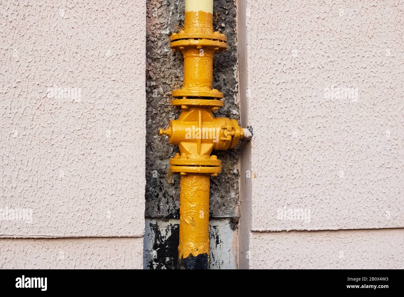 Yellow water pipe on a house wall Stock Photo - Alamy