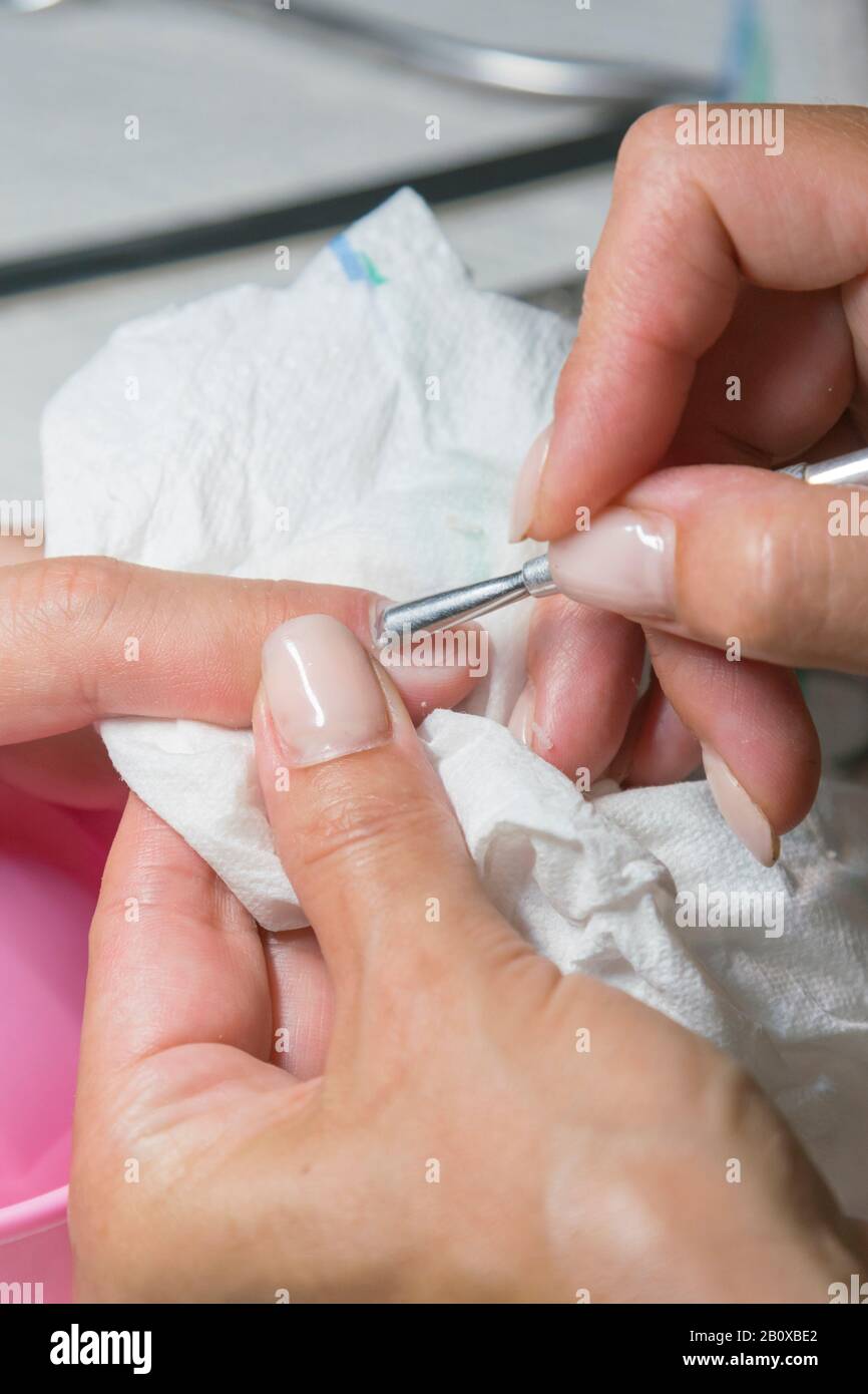 The process of removing cuticles in a beauty salon. Close-up. vertical ...