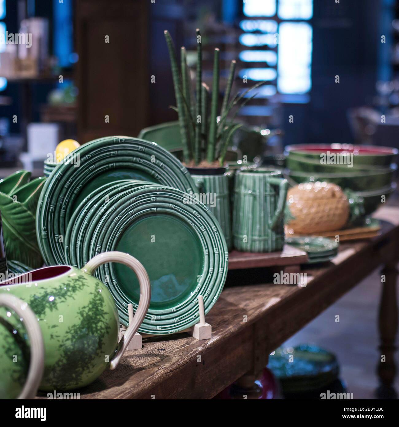 Green ceramic plates on a shelf in a store. Designer ceramic plates ...