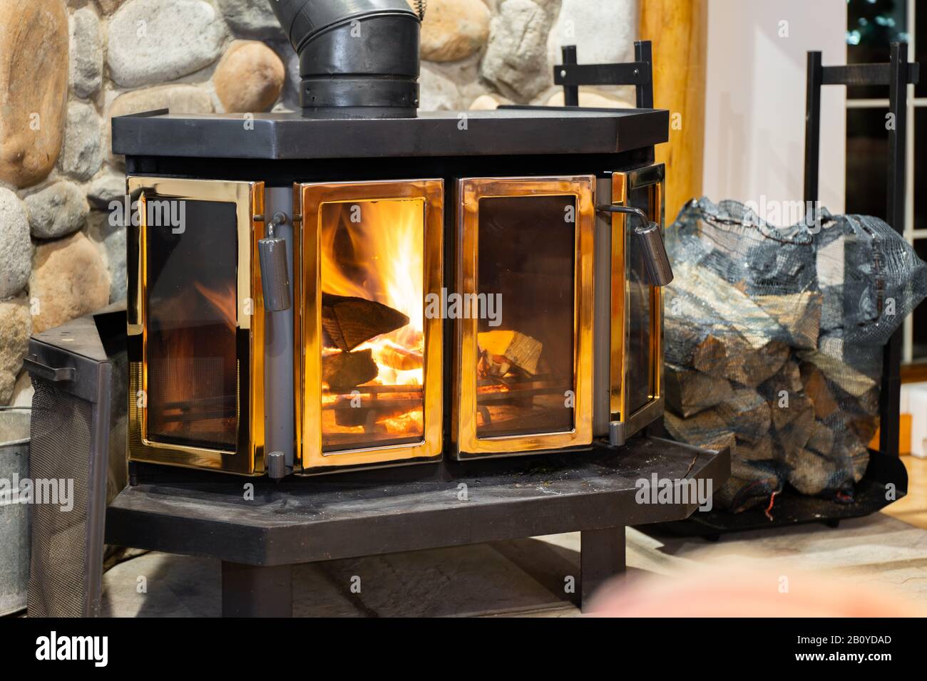 Wood stove fireplace with metal body and glass door in house with cozy ...