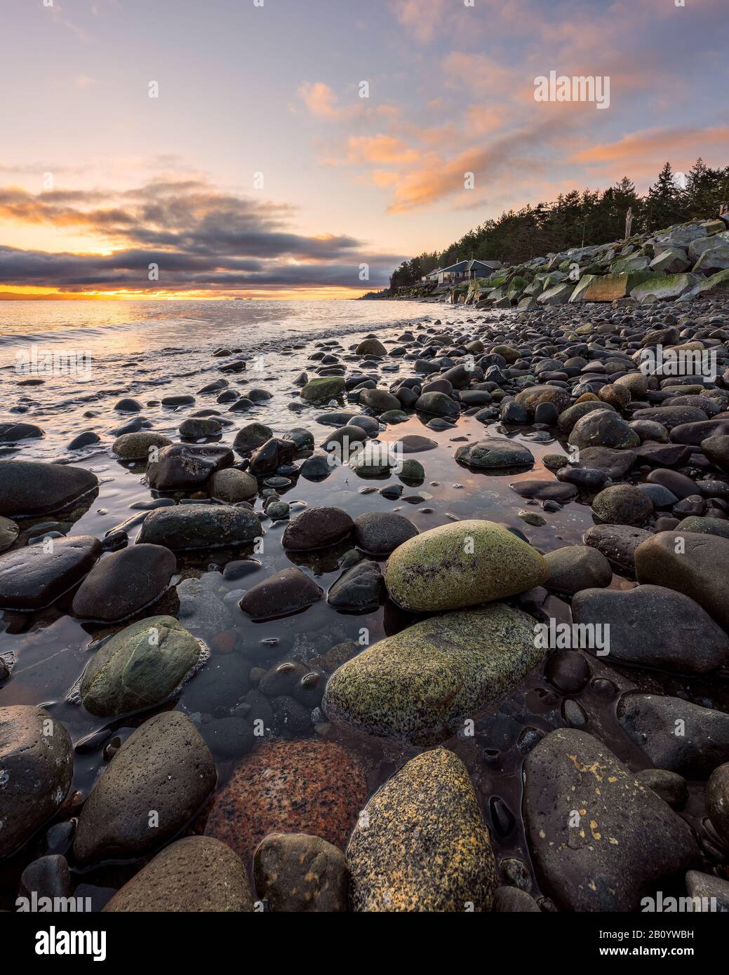 Beautiful colored rocks in front of sunrise along remote beach on ...