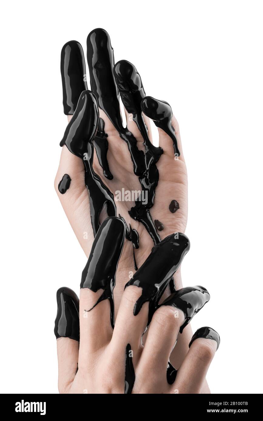 Female refined hand smeared with black and gold acrylic paint on a ...