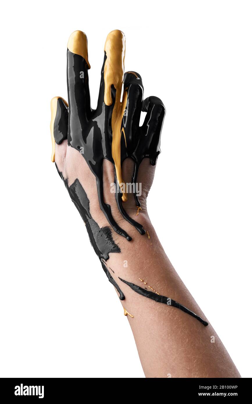 Female refined hand smeared with black and gold acrylic paint on a ...