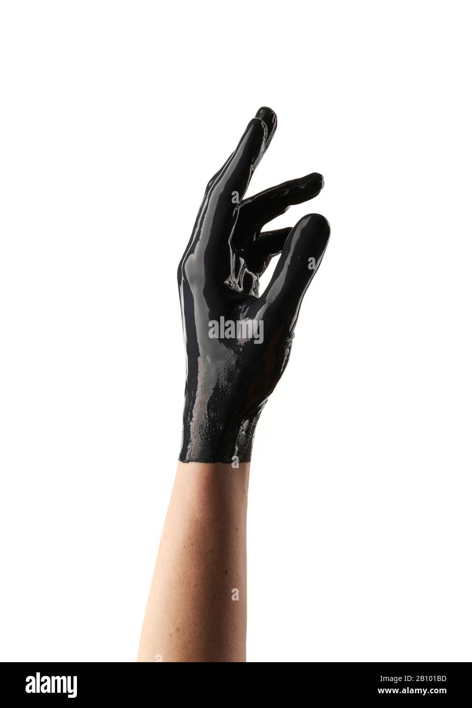 Female refined hand smeared with black and gold acrylic paint on a ...