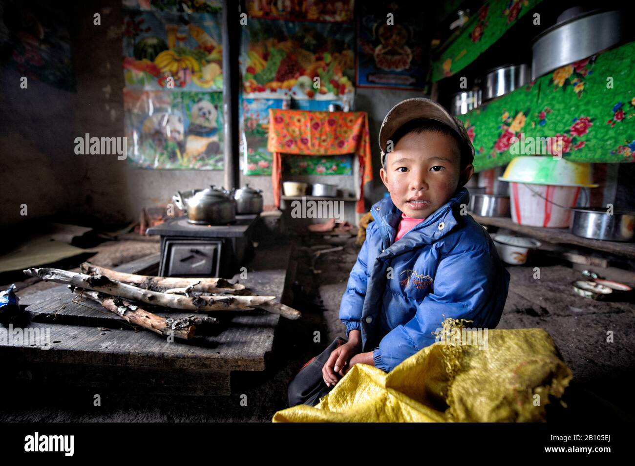 Tibetan child sits at the stove on cold days hi-res stock photography ...