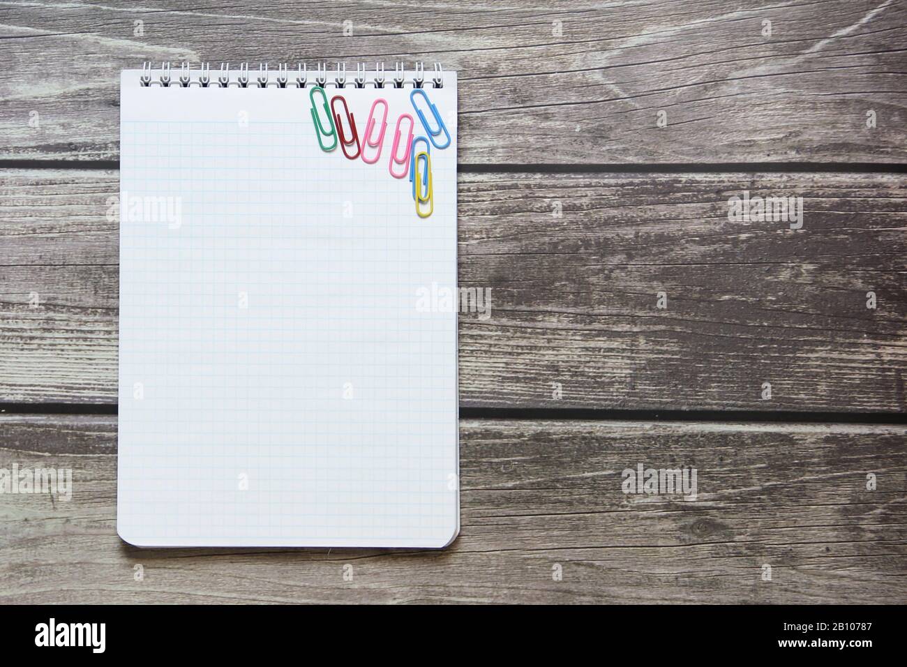 Notepad with a blank white sheet in a checker paper with paper clips ...
