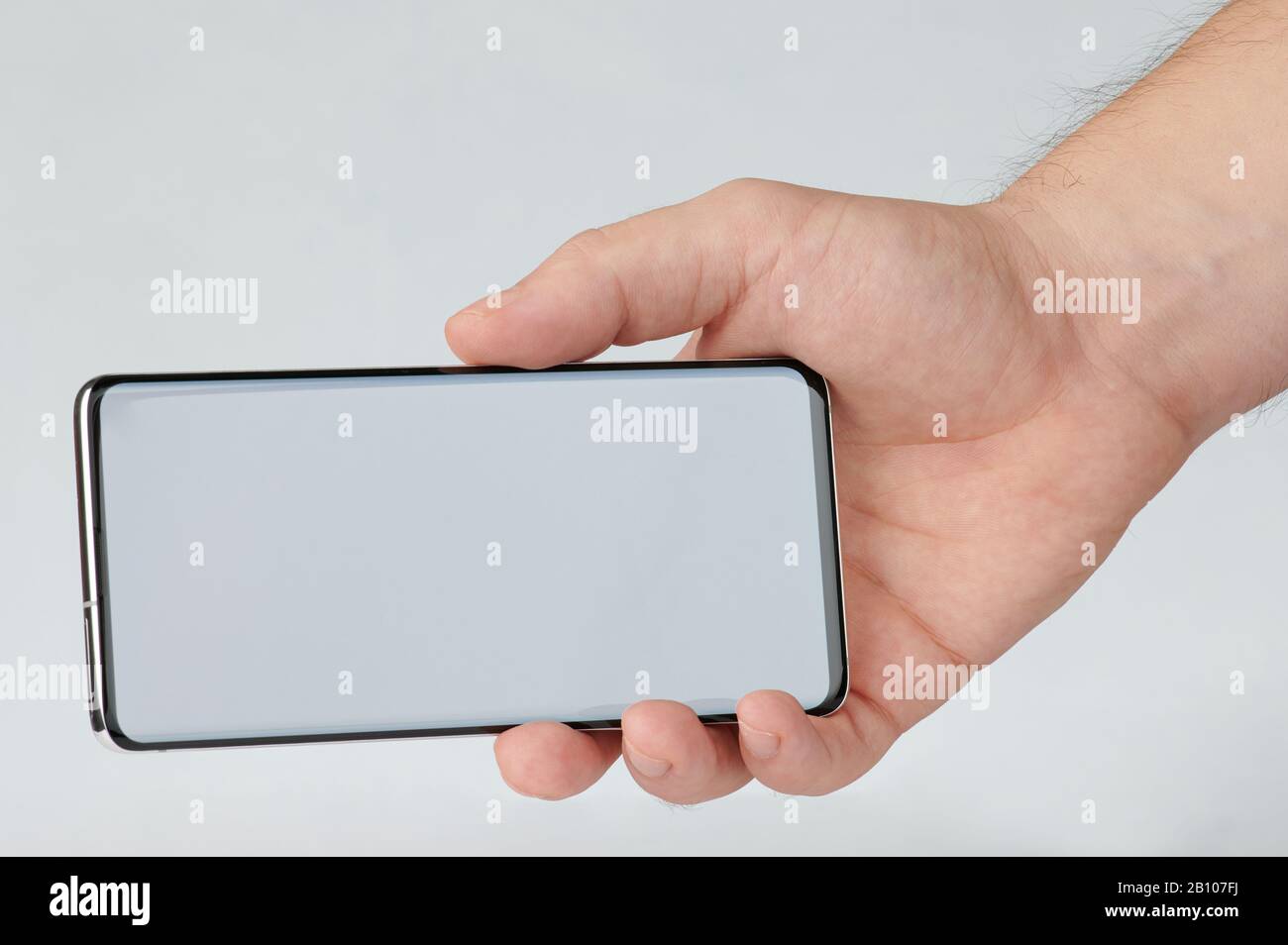 Hand show smartphone horizontal close up isolated on white background ...